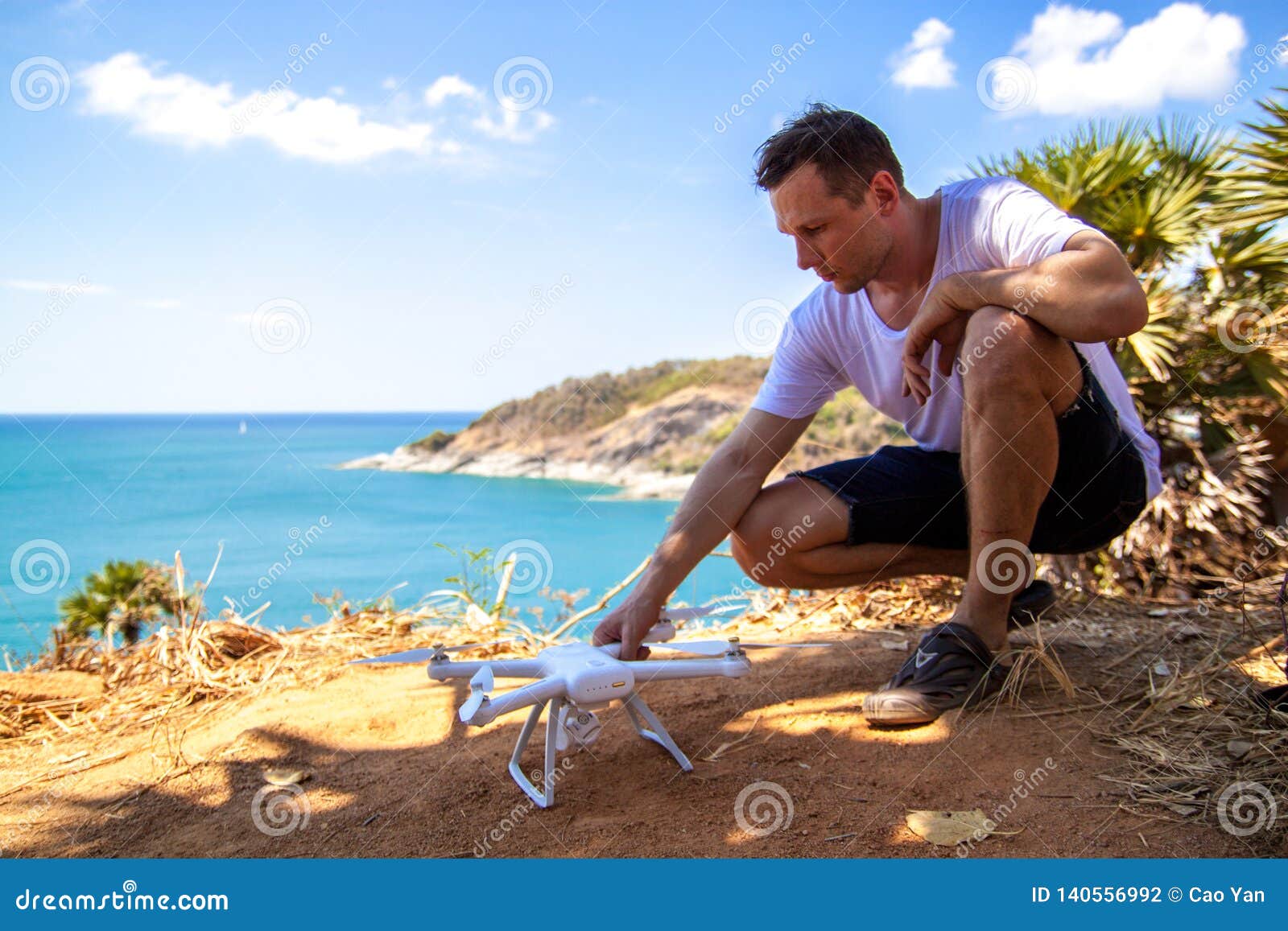 Man In A Shirt Operating A Drone With Remote Control On The Sea Stock