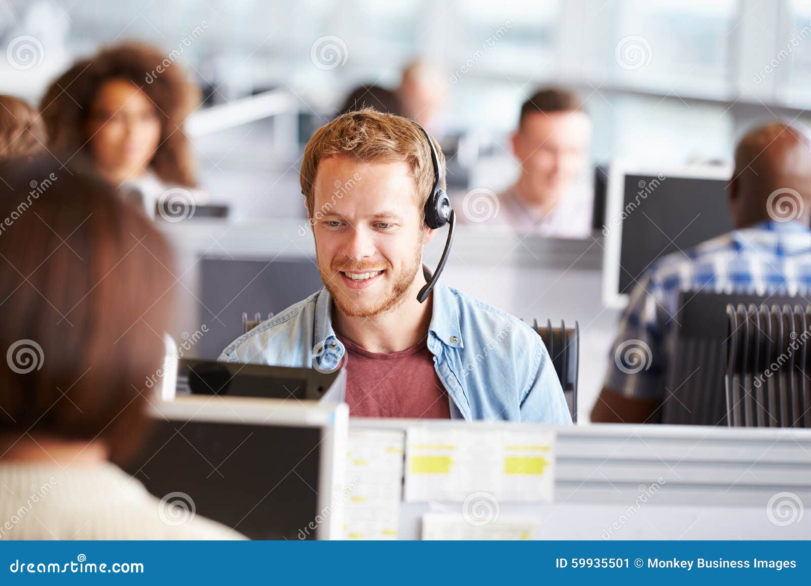 Young Man Working at a Computer in a Call Centre Stock Image - Image of ...