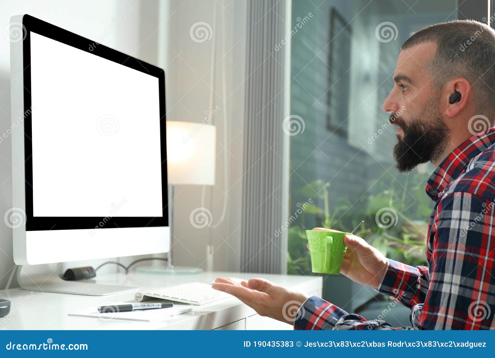 Young Man Working from Home in Front of Computer with Blank Screen ...