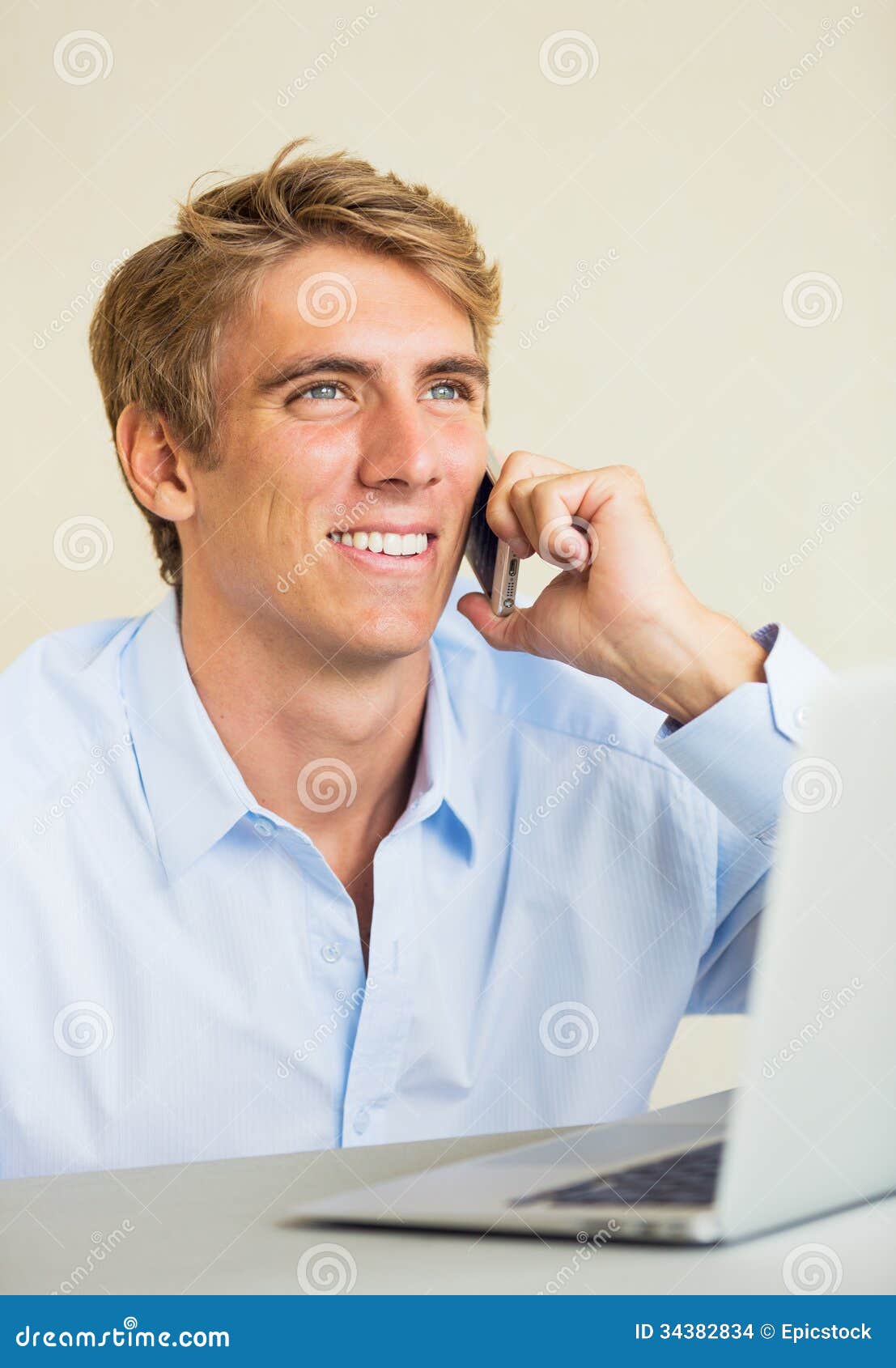 Young Man Working on Laptop Computer Talking on Phone Stock Photo ...