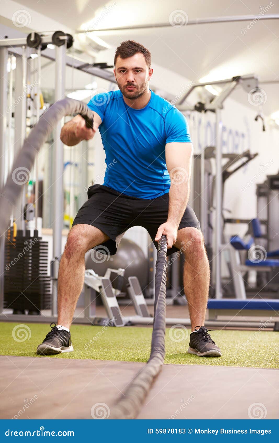 Young Man Working Out with Battle Ropes at a Gym, Vertical Stock Image ...