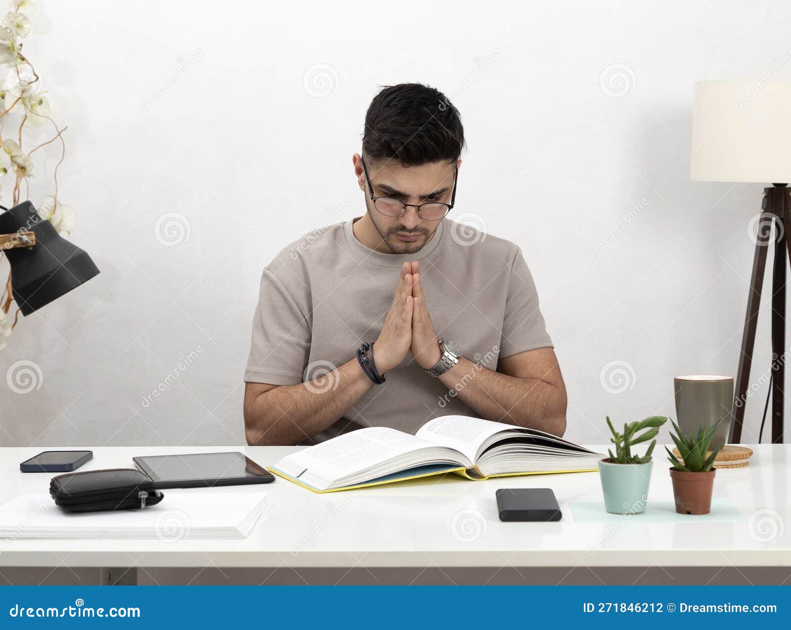 Young Man Working and Praying in His Home Office.education.business.e ...
