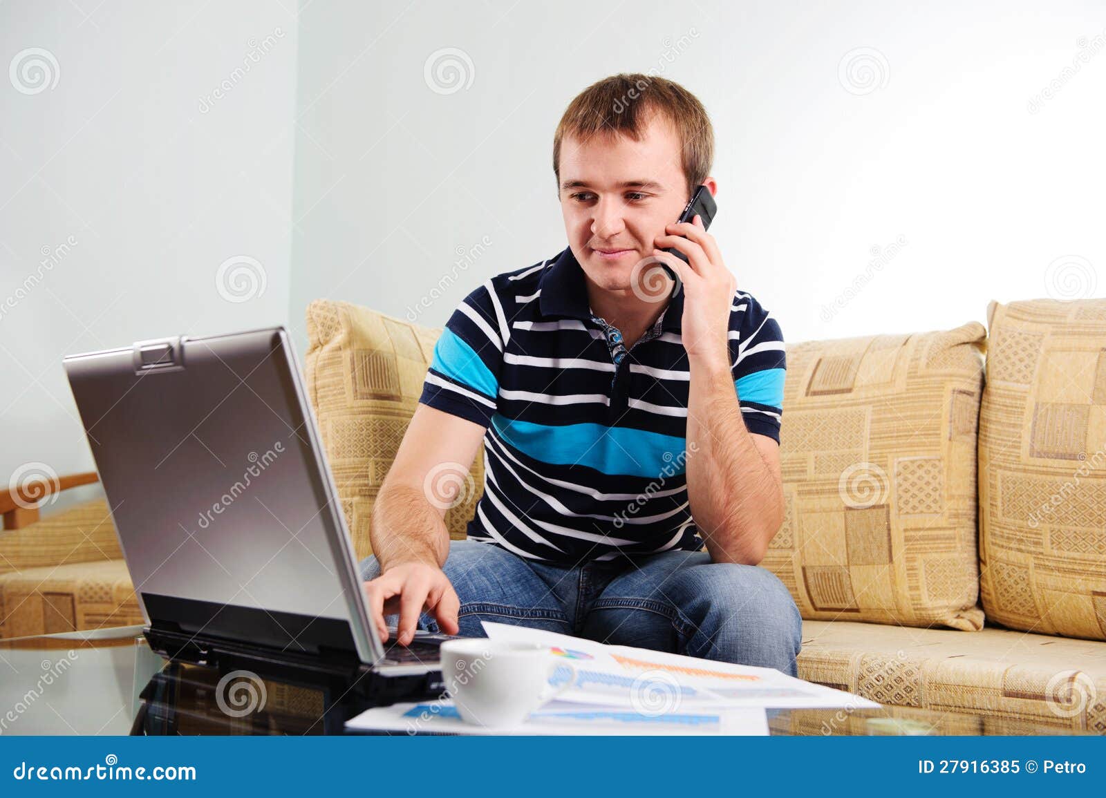 Young man working on sofa stock image. Image of phone - 27916385