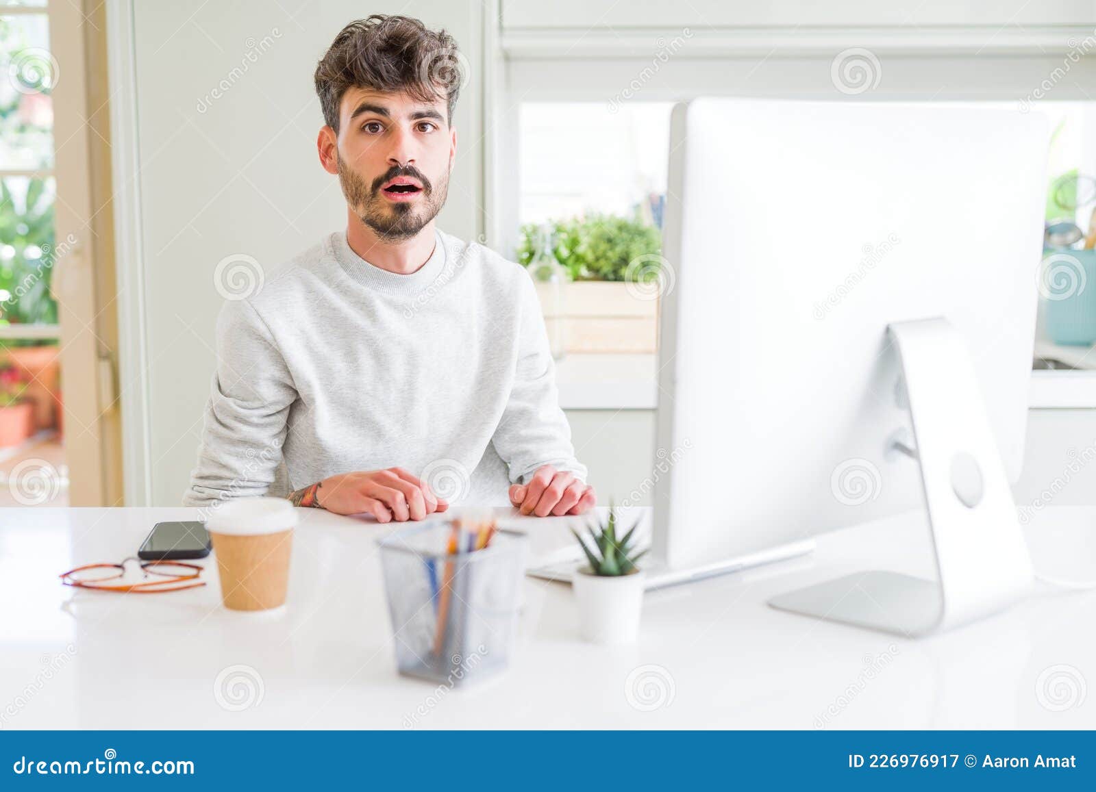 Young Man Working Using Computer Afraid and Shocked with Surprise ...