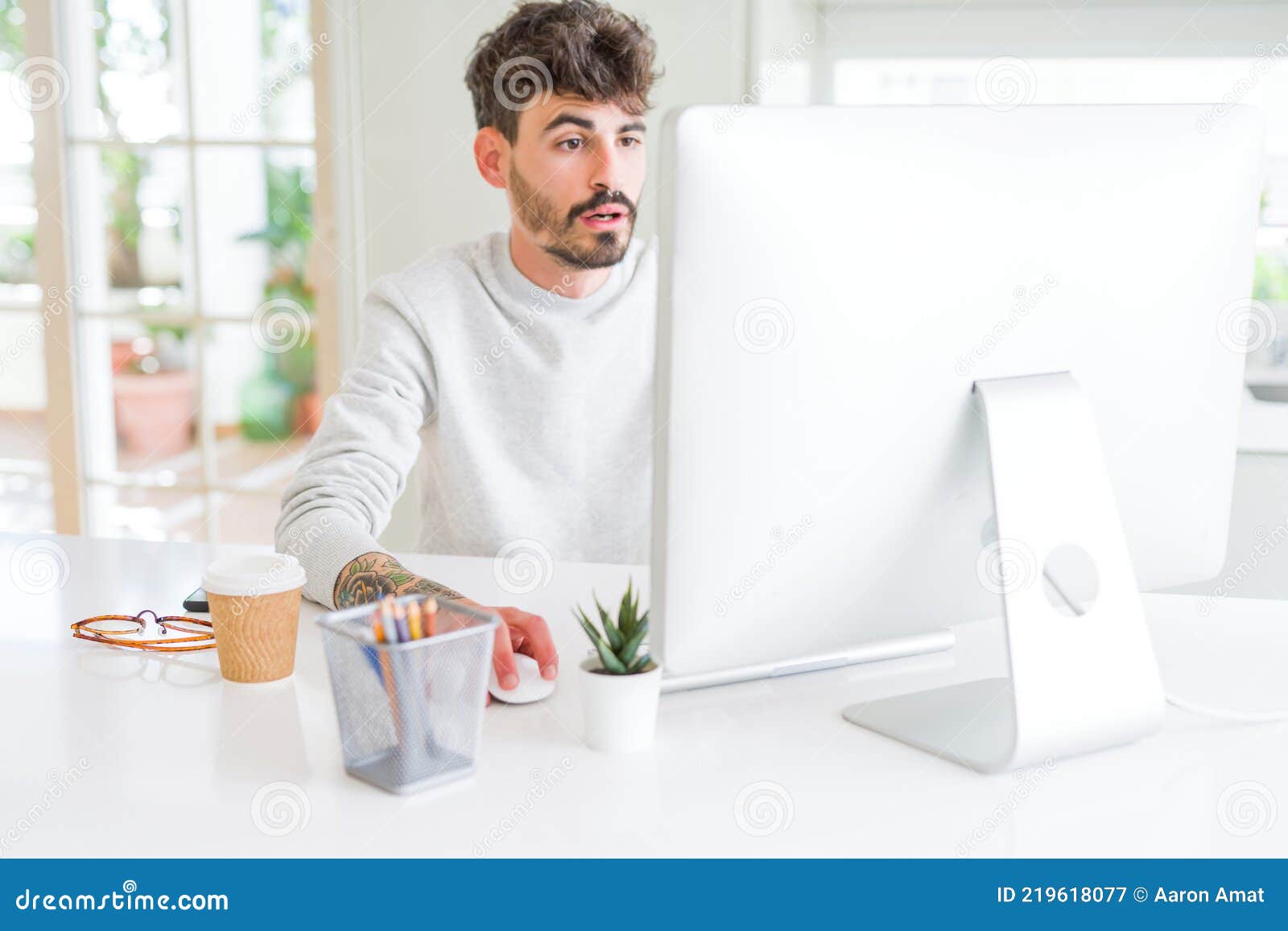 Young Man Working Using Computer Scared in Shock with a Surprise Face ...