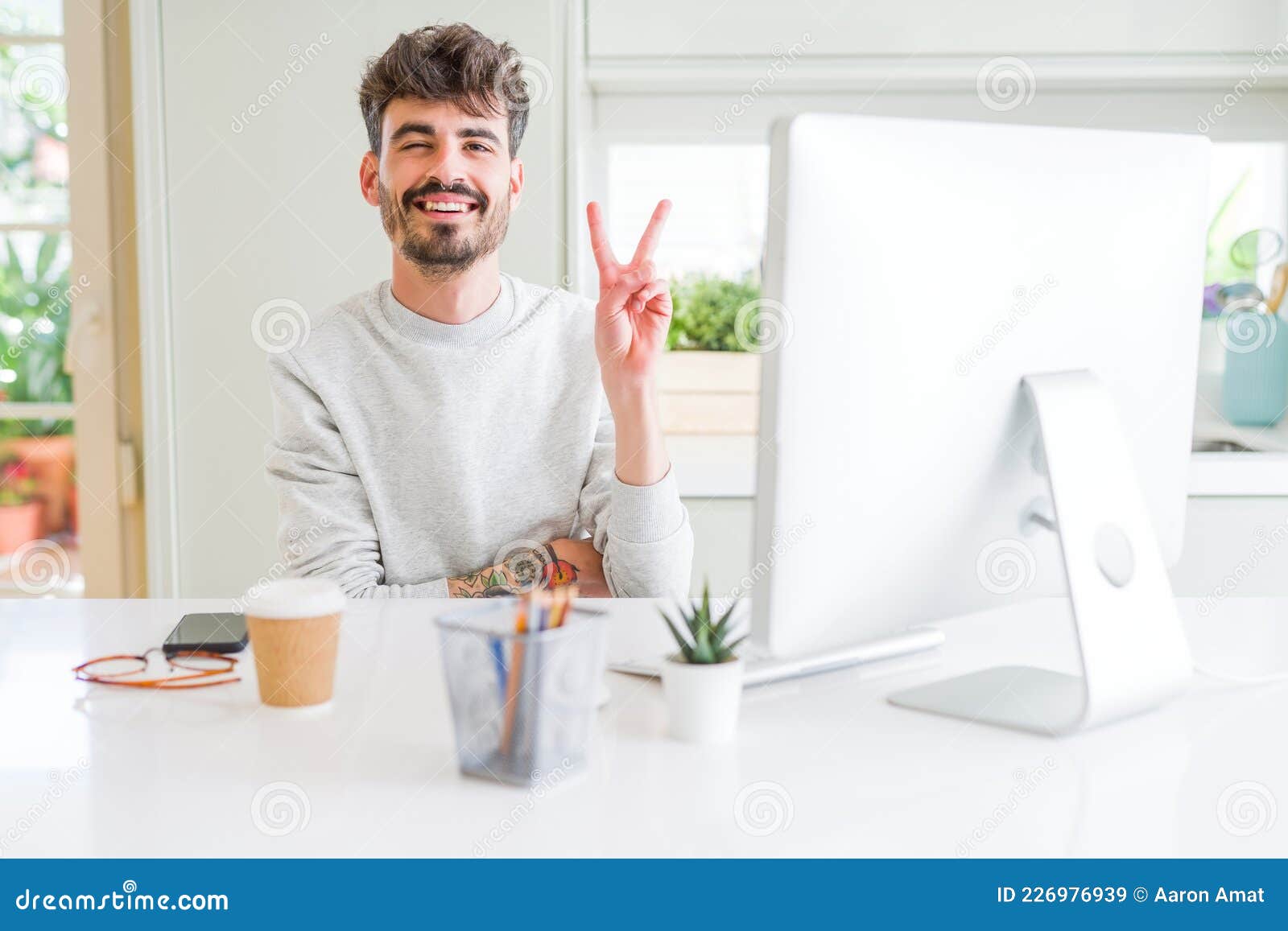 Young Man Working Using Computer Smiling with Happy Face Winking at the ...