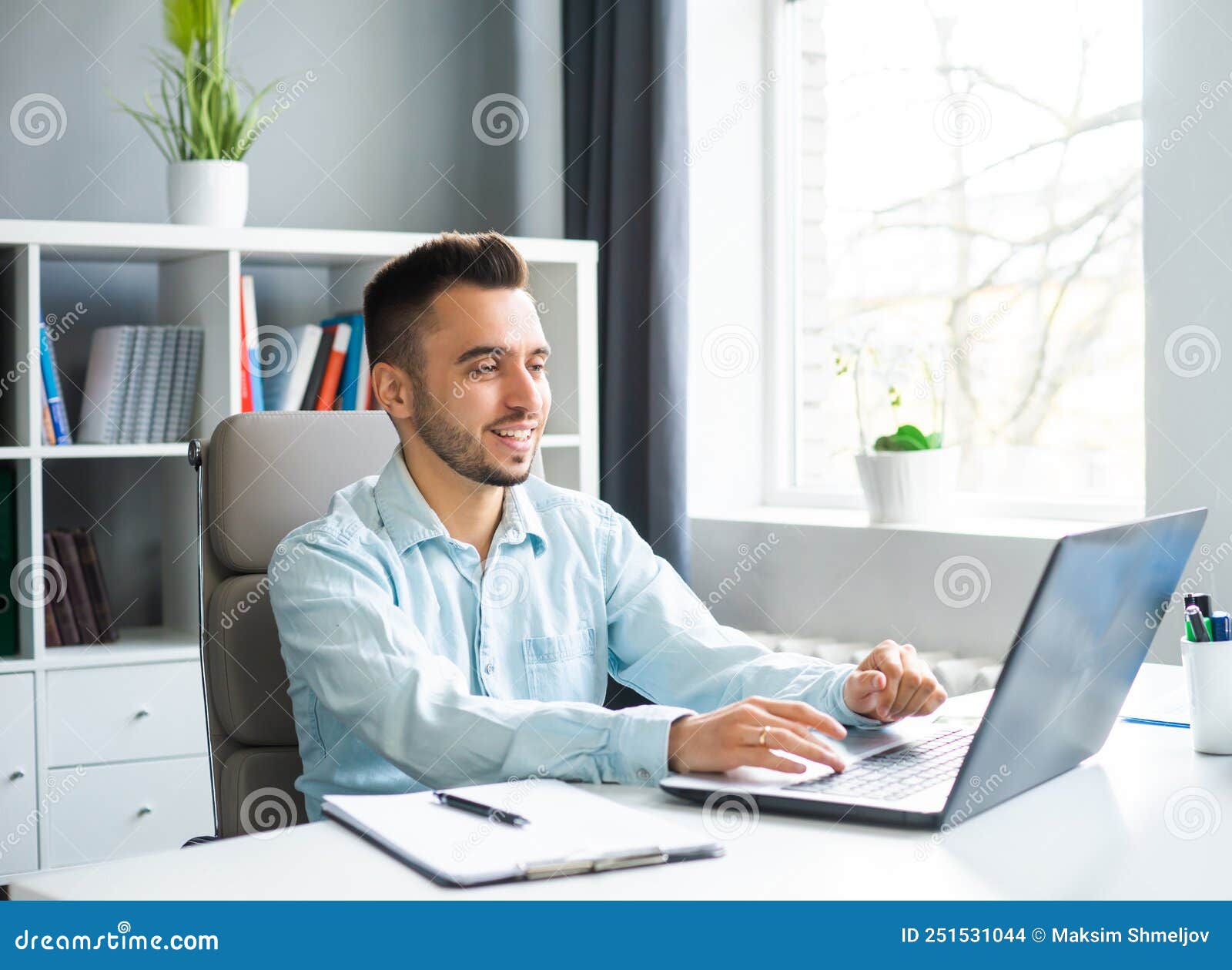 Young Man Works while Sitting in Front of a Computer at Home. the ...