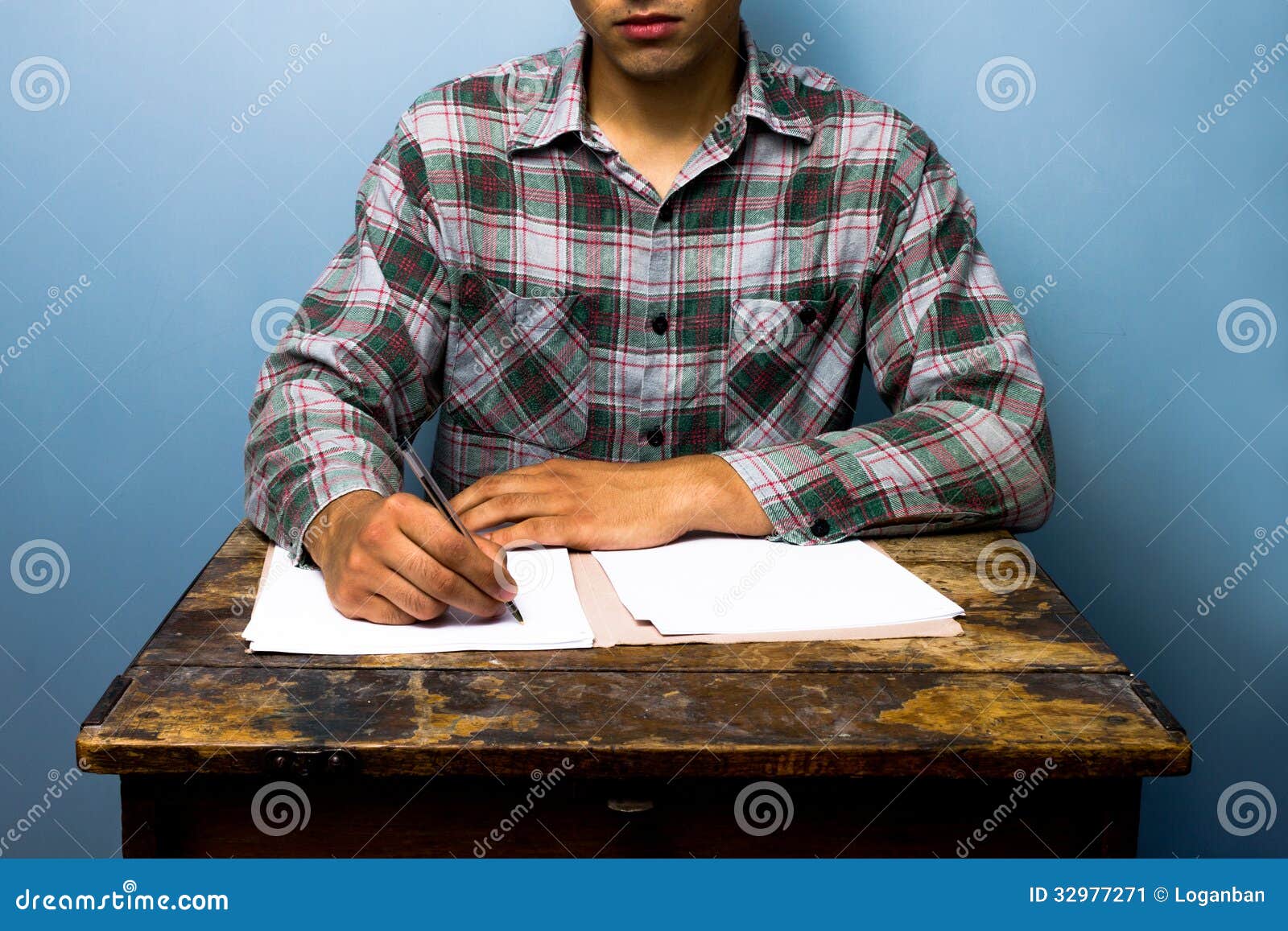 Young man writing at desk stock image. Image of seated - 32977271