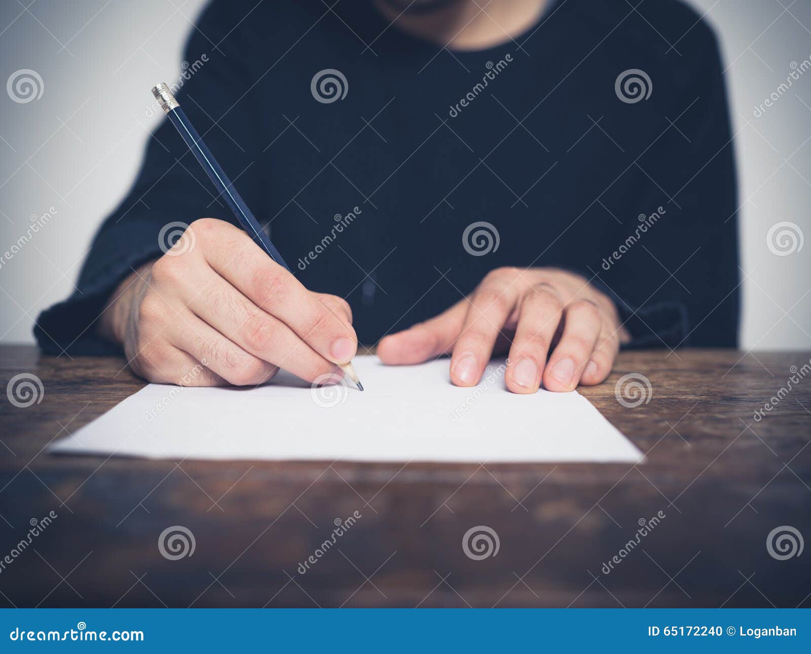 Young man writing at table stock photo. Image of alone - 65172240
