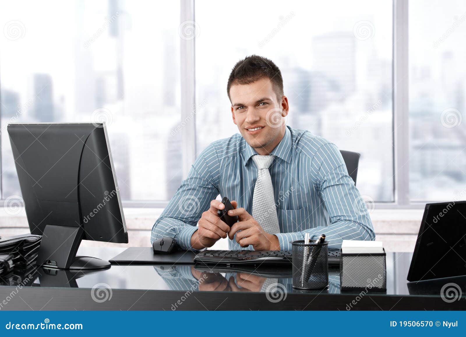 Young Manager Smiling at Desk Stock Photo - Image of mobilephone, light ...