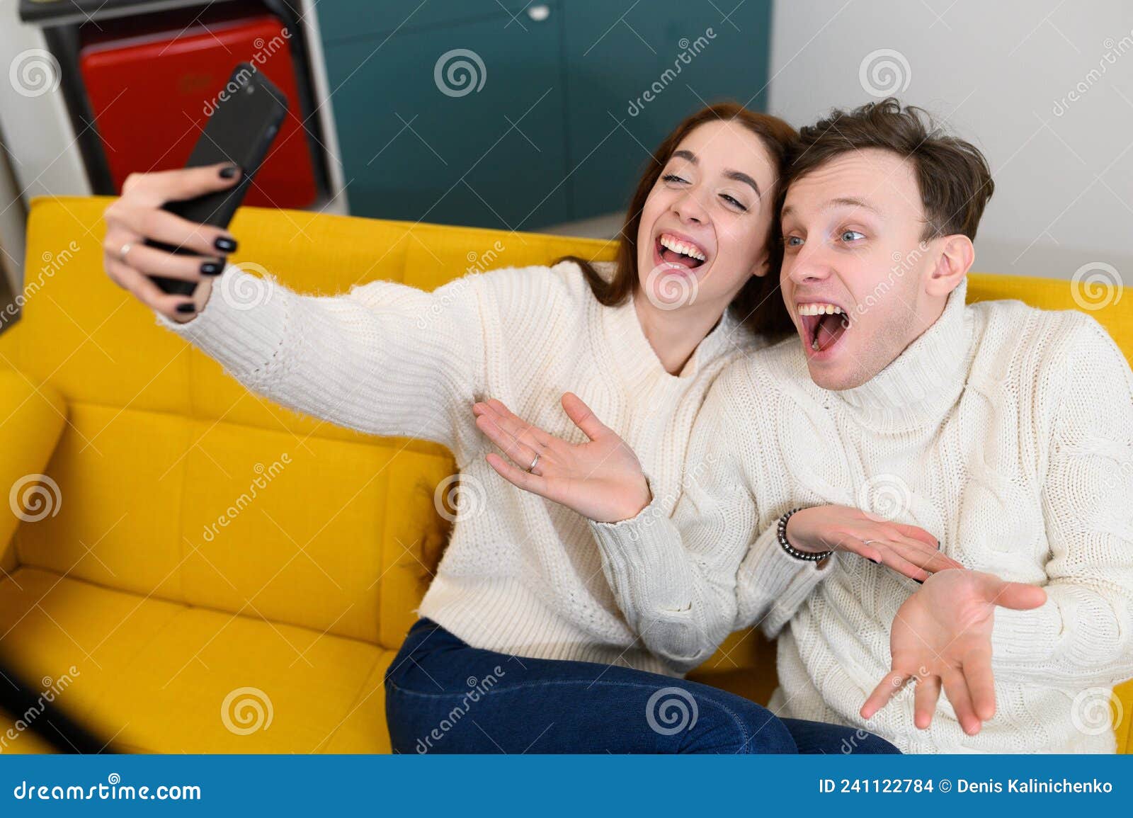 A Young Married Couple at Home. they Sit on the Couch and Take Selfies ...