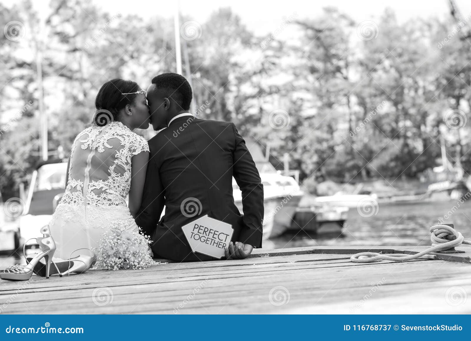Romantic Couple Sitting At A Wooden Dock And Express Their Love Stock