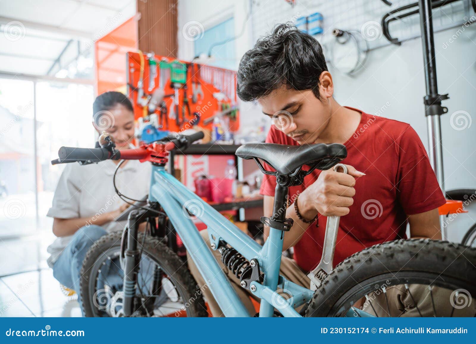 Young Mechanic Assembling a New Bicycle Using a Wrench in the Shop ...