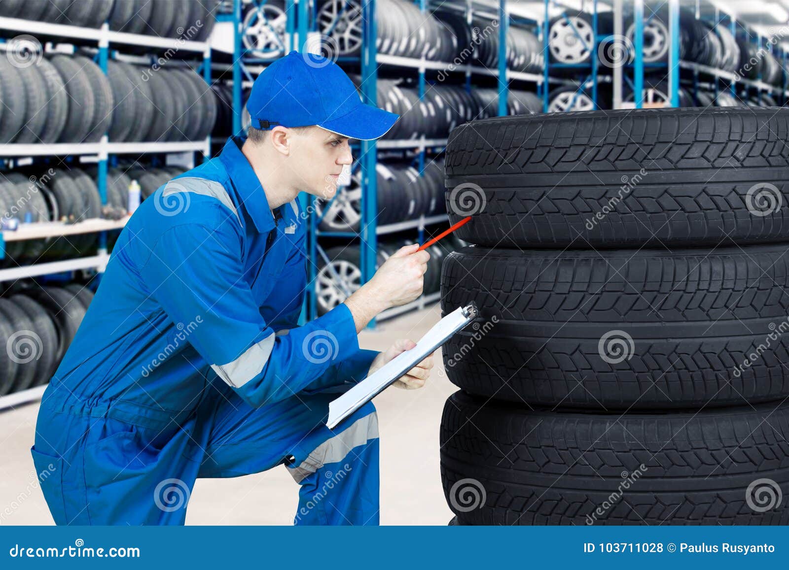 Young Mechanic Checking Tyre in Workshop Stock Photo - Image of ...