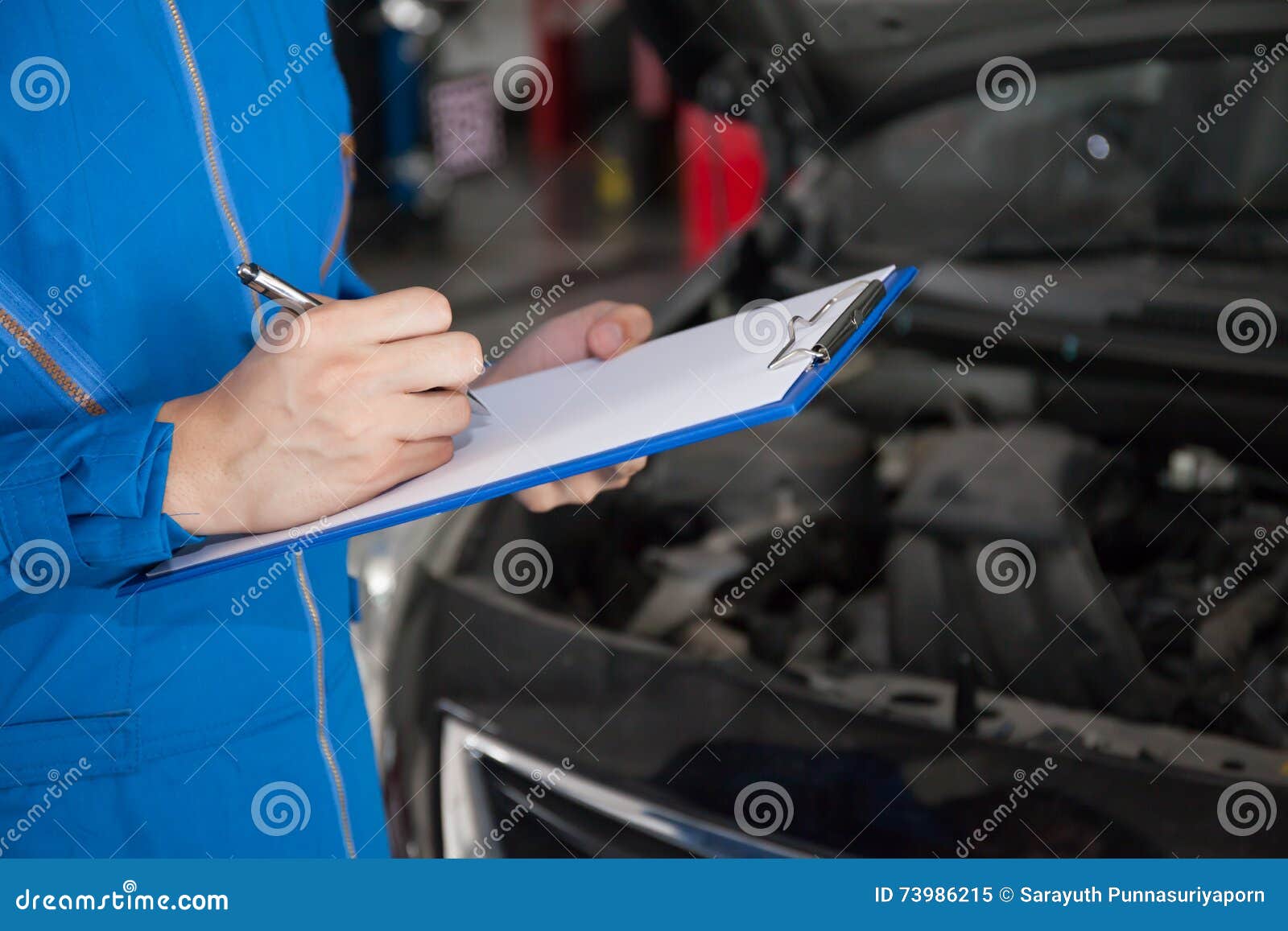 Young Mechanic Engineer Taking a Note on Clipboard for Examining Stock ...