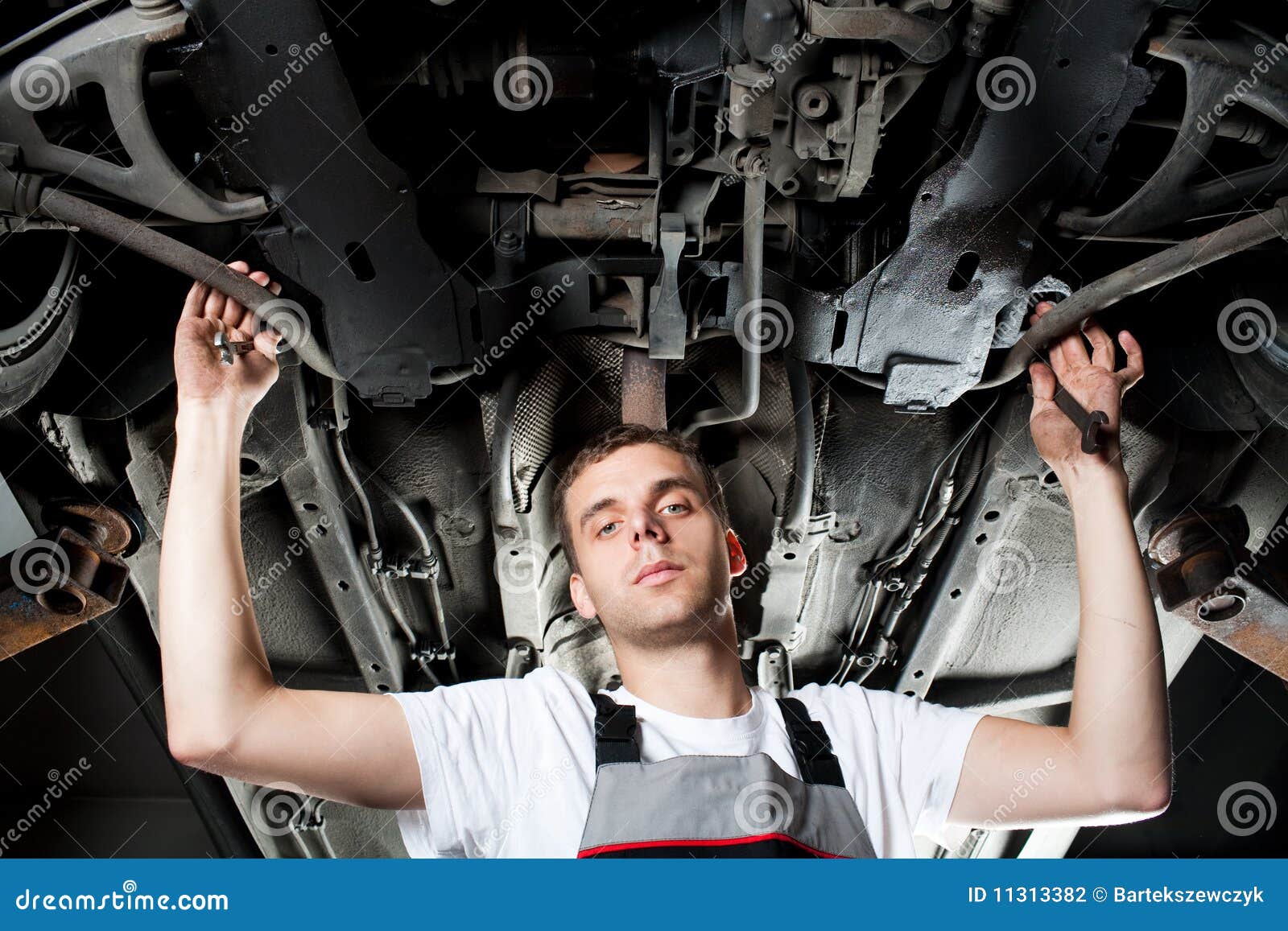 Young Mechanic Working Below Car in Uniform Stock Photo - Image of ...