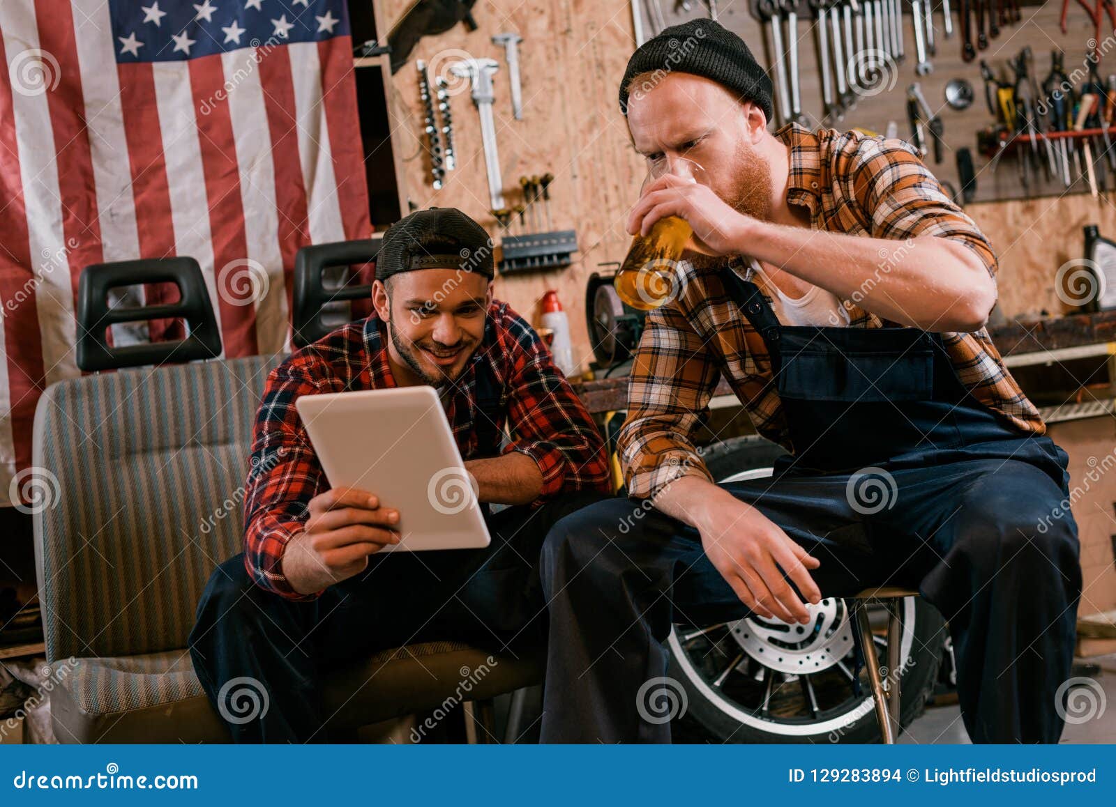 Young Mechanics Drinking Beer and Using Tablet Together Stock Photo ...