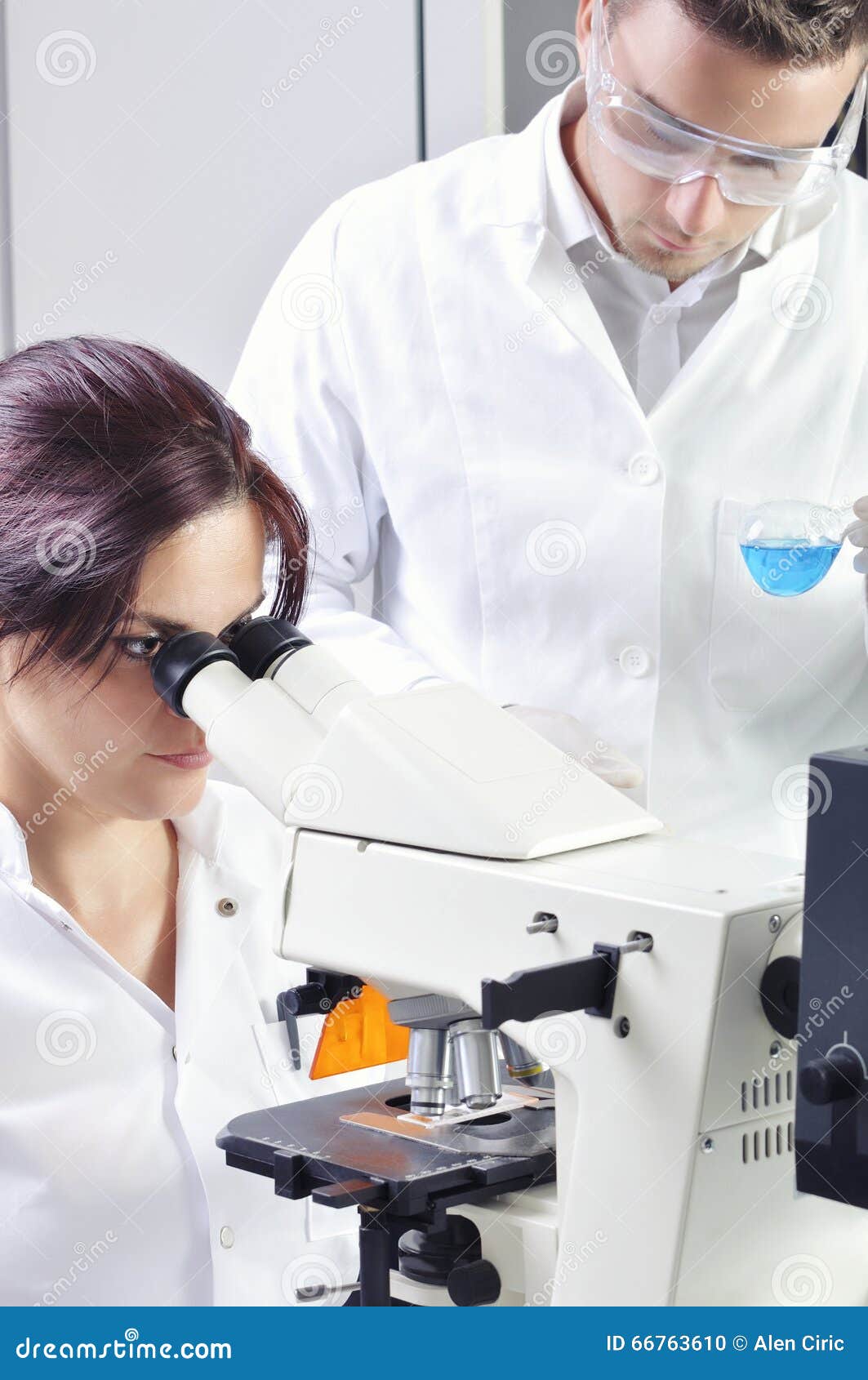 Young Medical Scientists Studying New Substance or Virus in Microscope ...