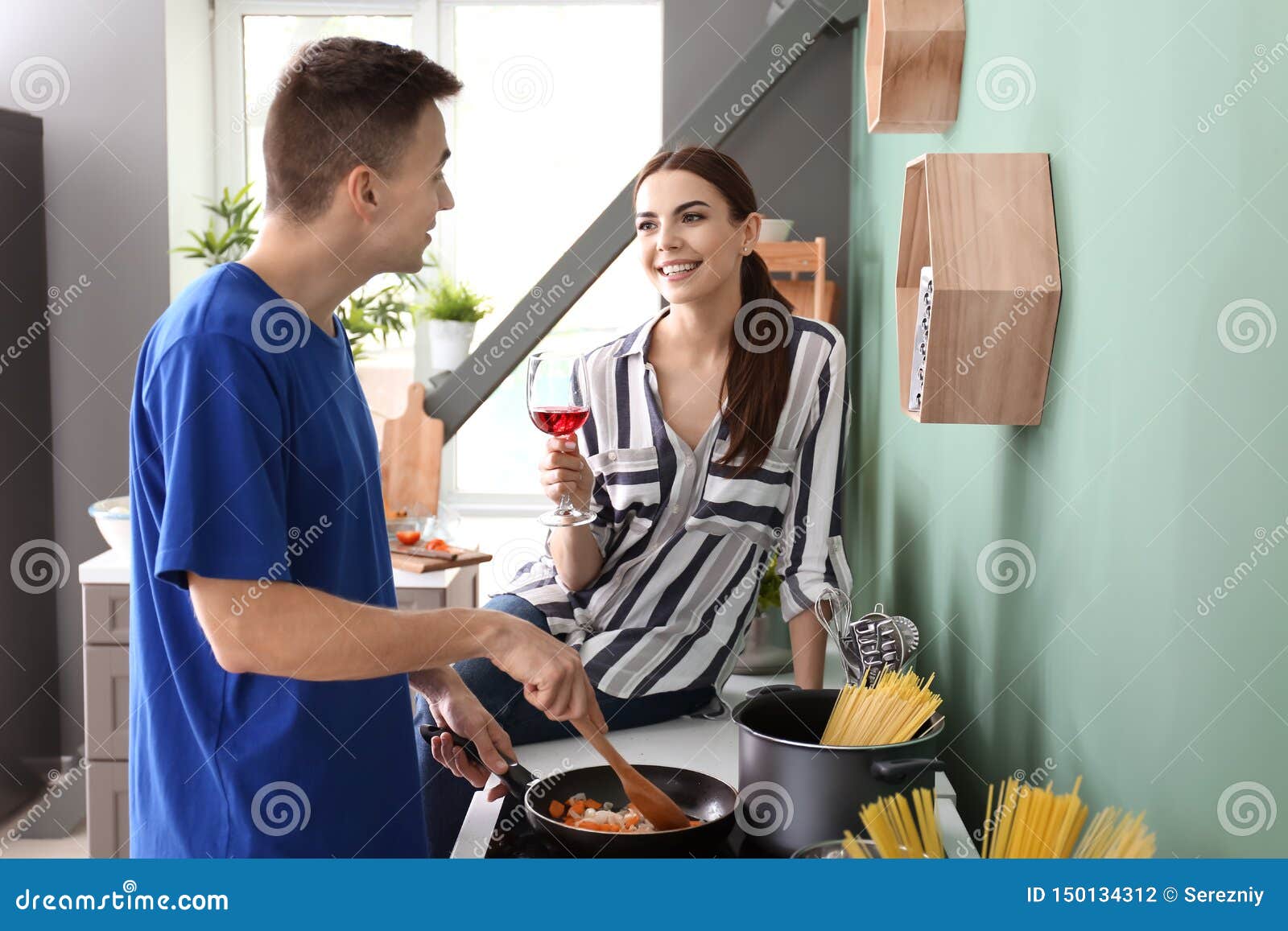 Young Man Cooking with Girlfriend in Kitchen Stock Photo - Image of ...