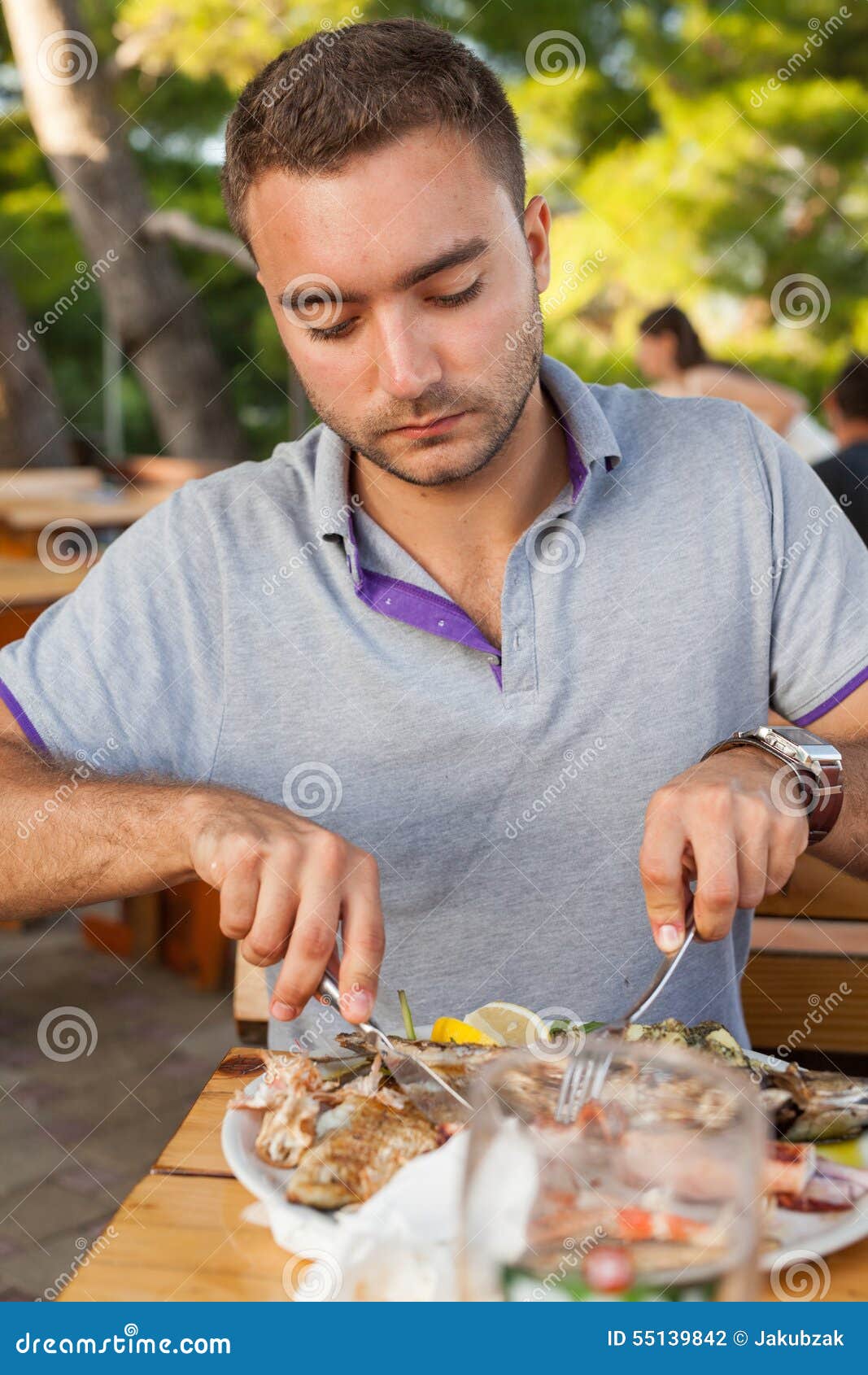 Young Men Sittin Behind the Table and Eating Seafod. Stock Photo ...