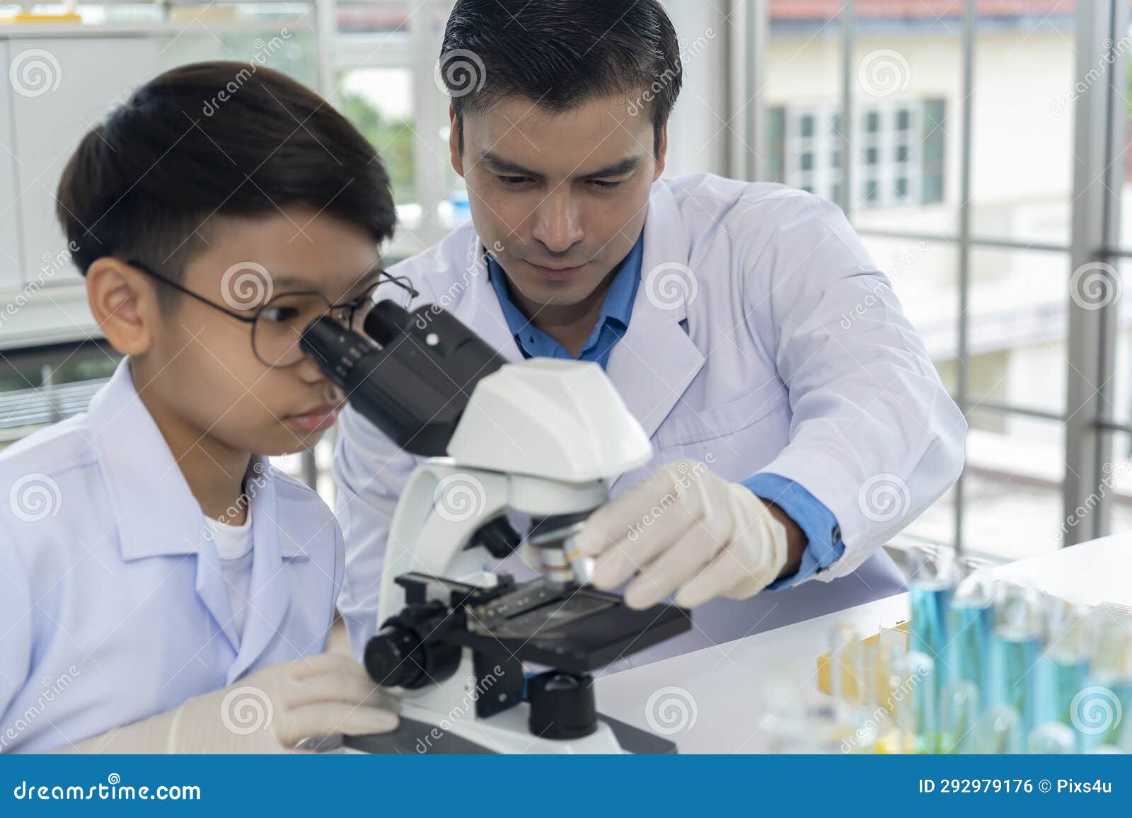 Young Teacher and Boy Use Microscope in Science Class at Laboratory ...