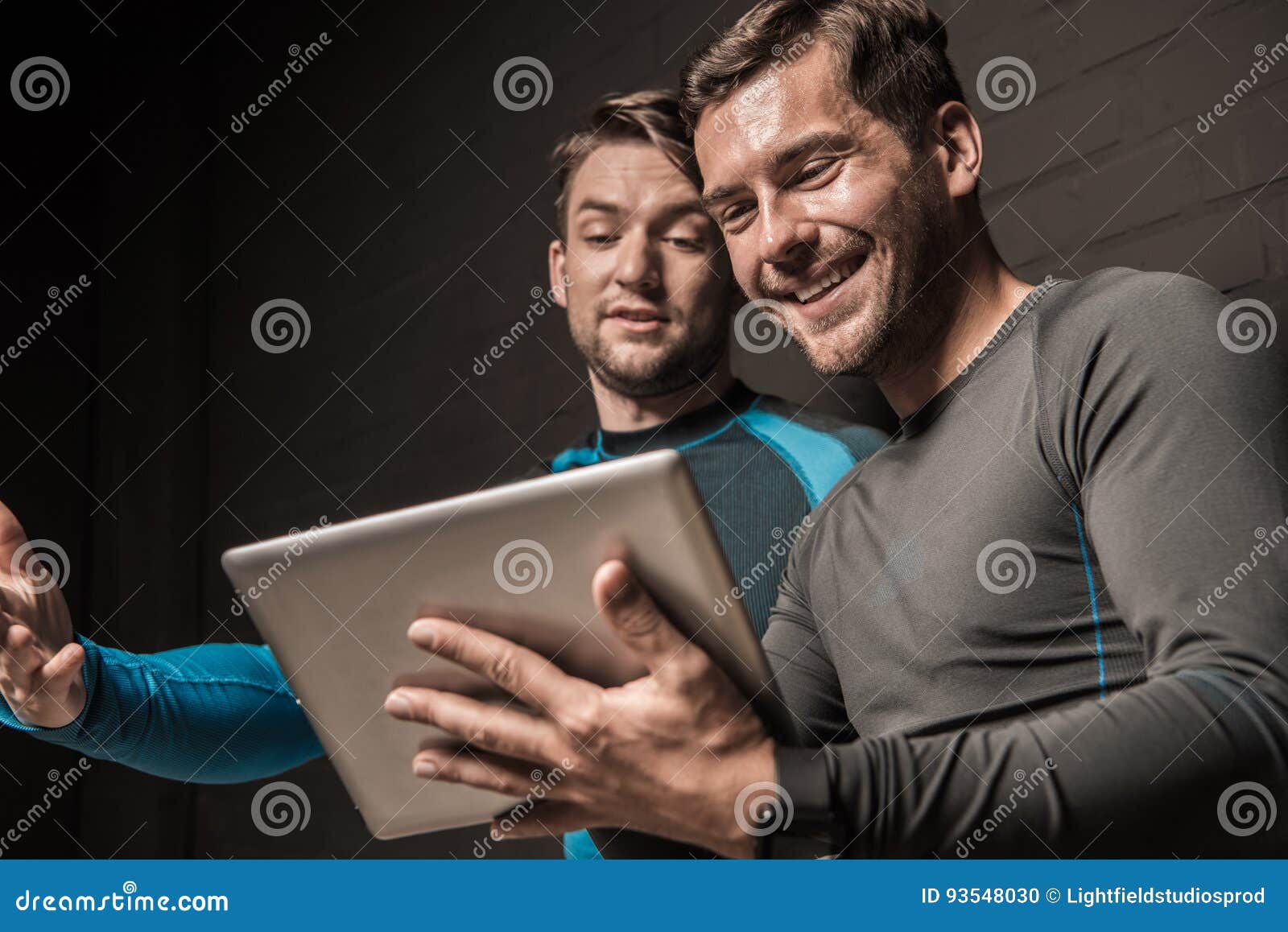 Young Men Using Tablet Computer Together Stock Photo - Image of ...