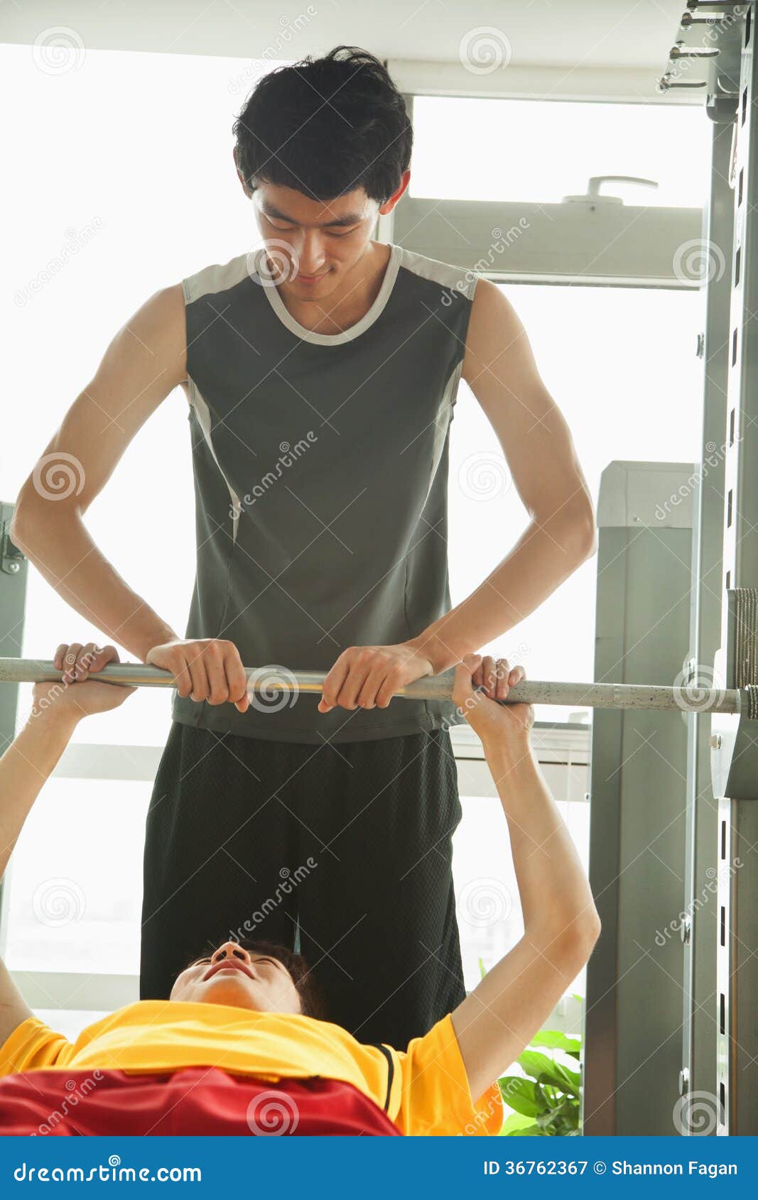 Young Men Weight Lifting with His Personal Trainer in the Gym Stock ...