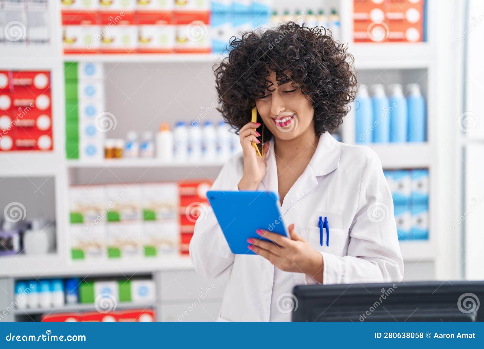 Young Middle East Woman Pharmacist Talking on Smartphone Using Touchpad ...