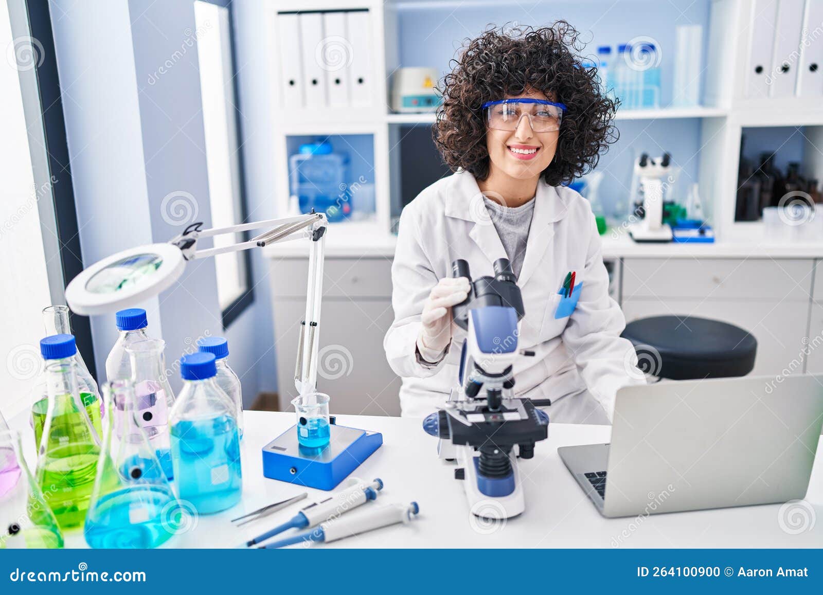 Young Middle East Woman Scientist Using Laptop and Microscope at ...