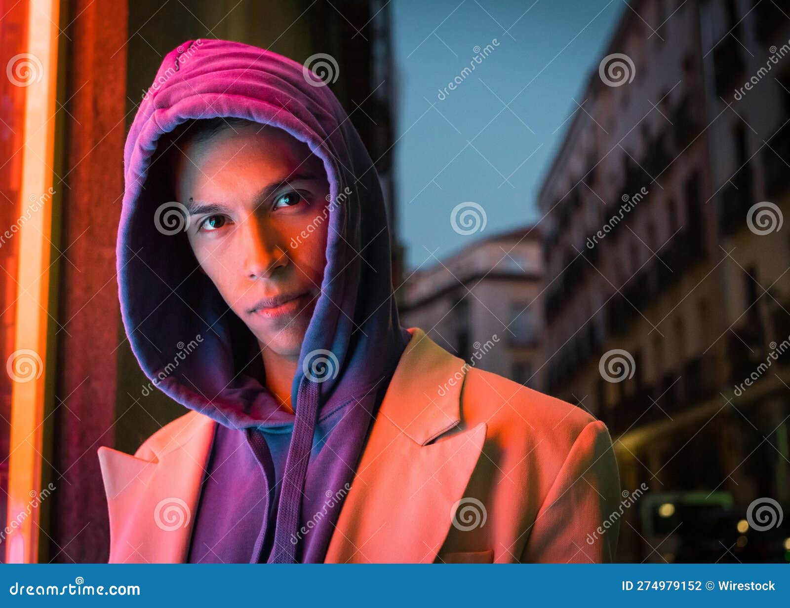 Young Millennial Hispanic Man with Red Neon Light Reflection and a Hood ...