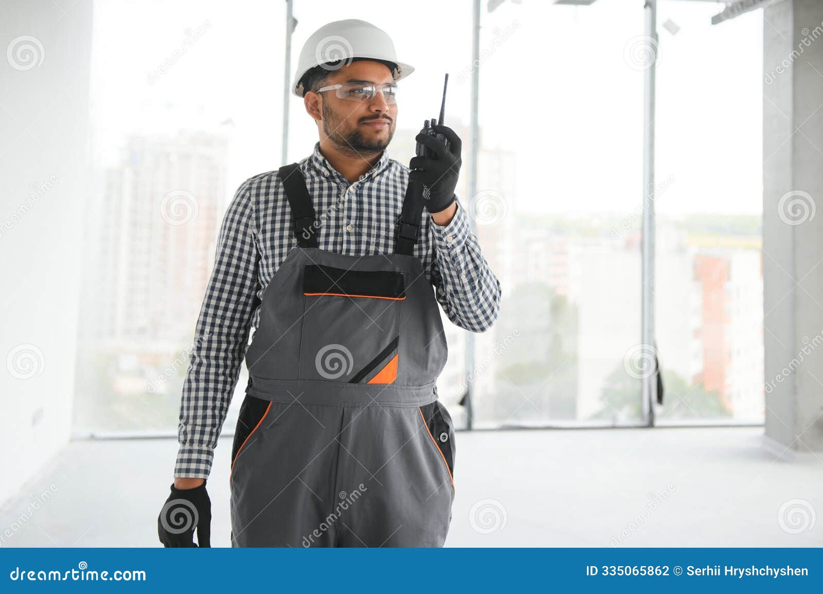 Young Mixed Race Supervisor Instructing Workers Using Walkie-talkie at ...