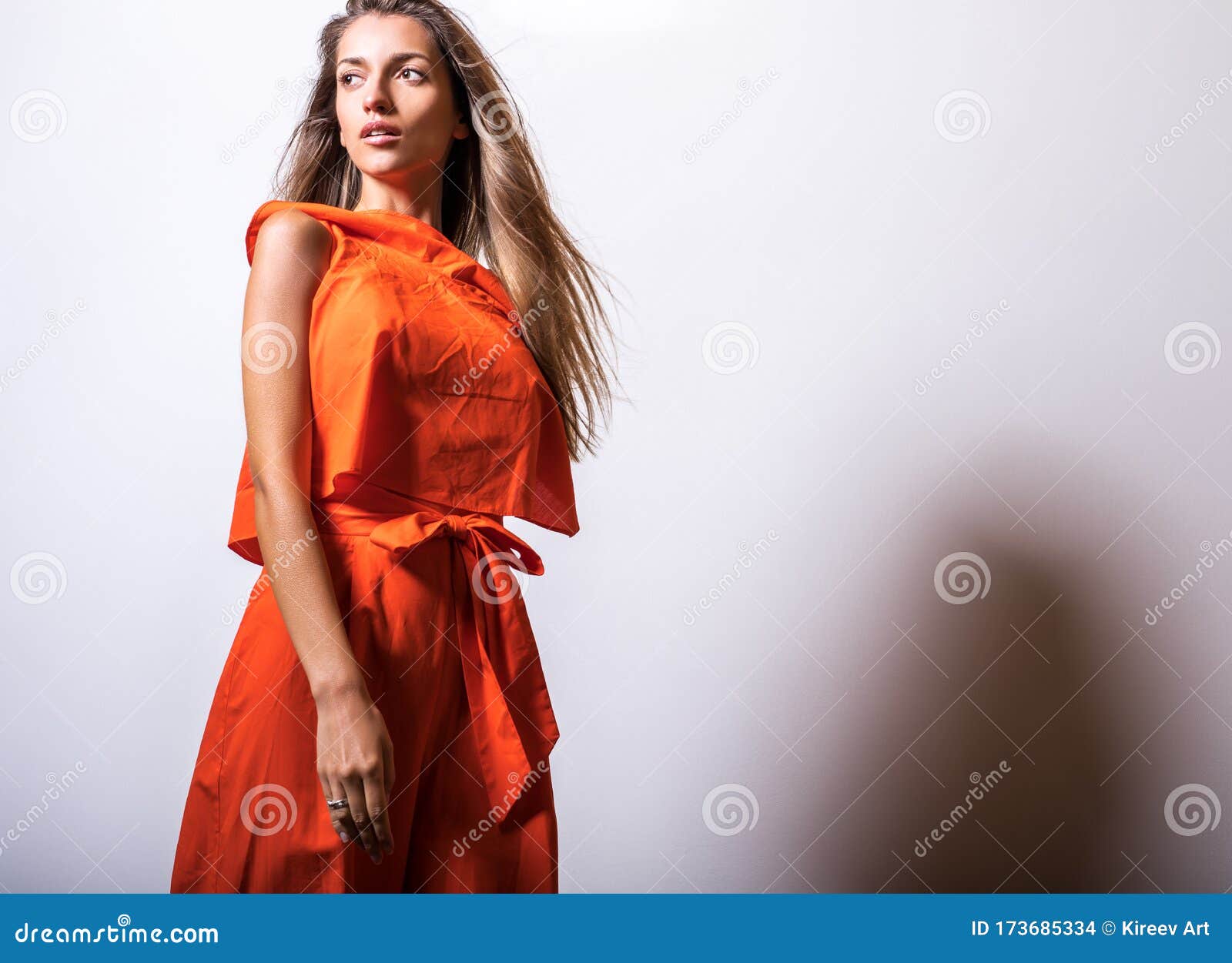 Young Model Woman in Orange Dress Pose in Studio. Stock Photo - Image ...