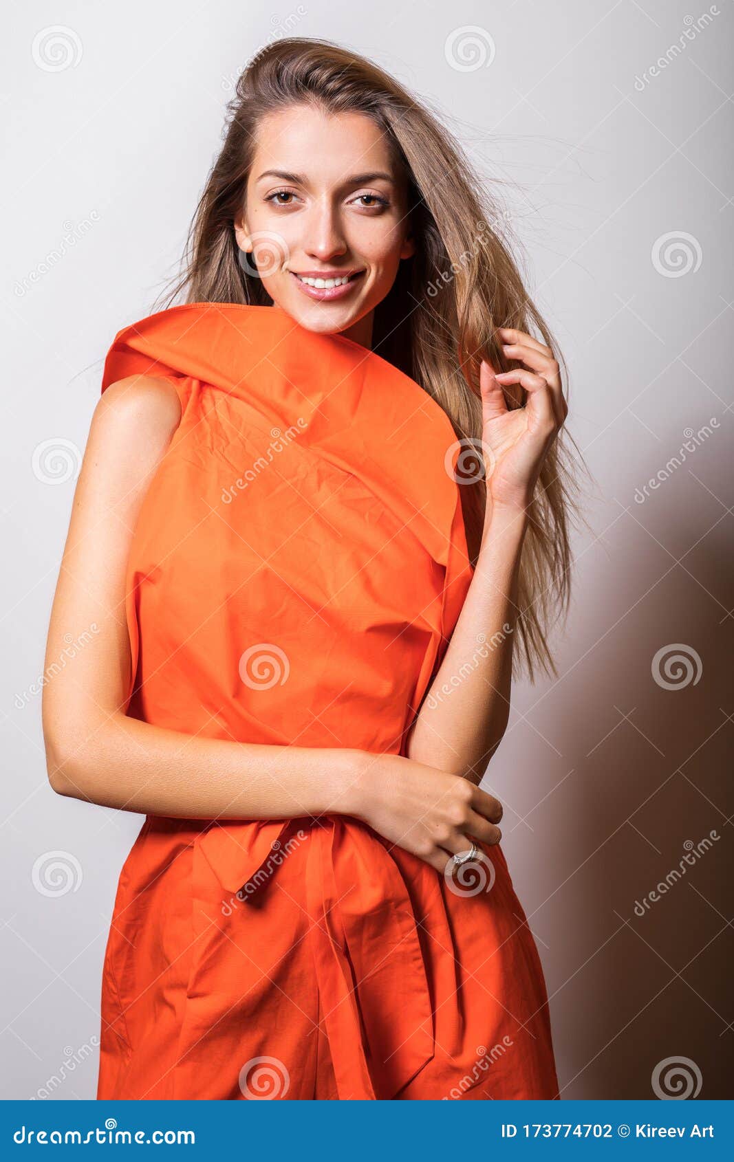 Young Model Woman in Orange Dress Pose in Studio. Stock Photo - Image ...