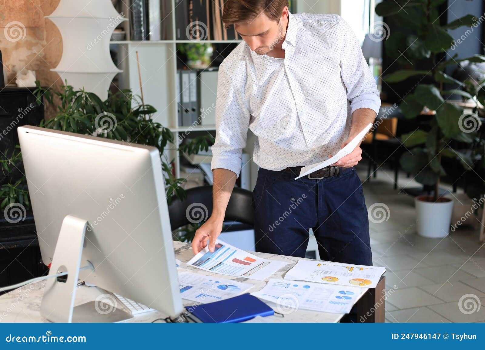 Young Modern Business Man Analyzing Data Using Computer while Working ... Young Modern Business Man Analyzing Data Using Computer while Working ...