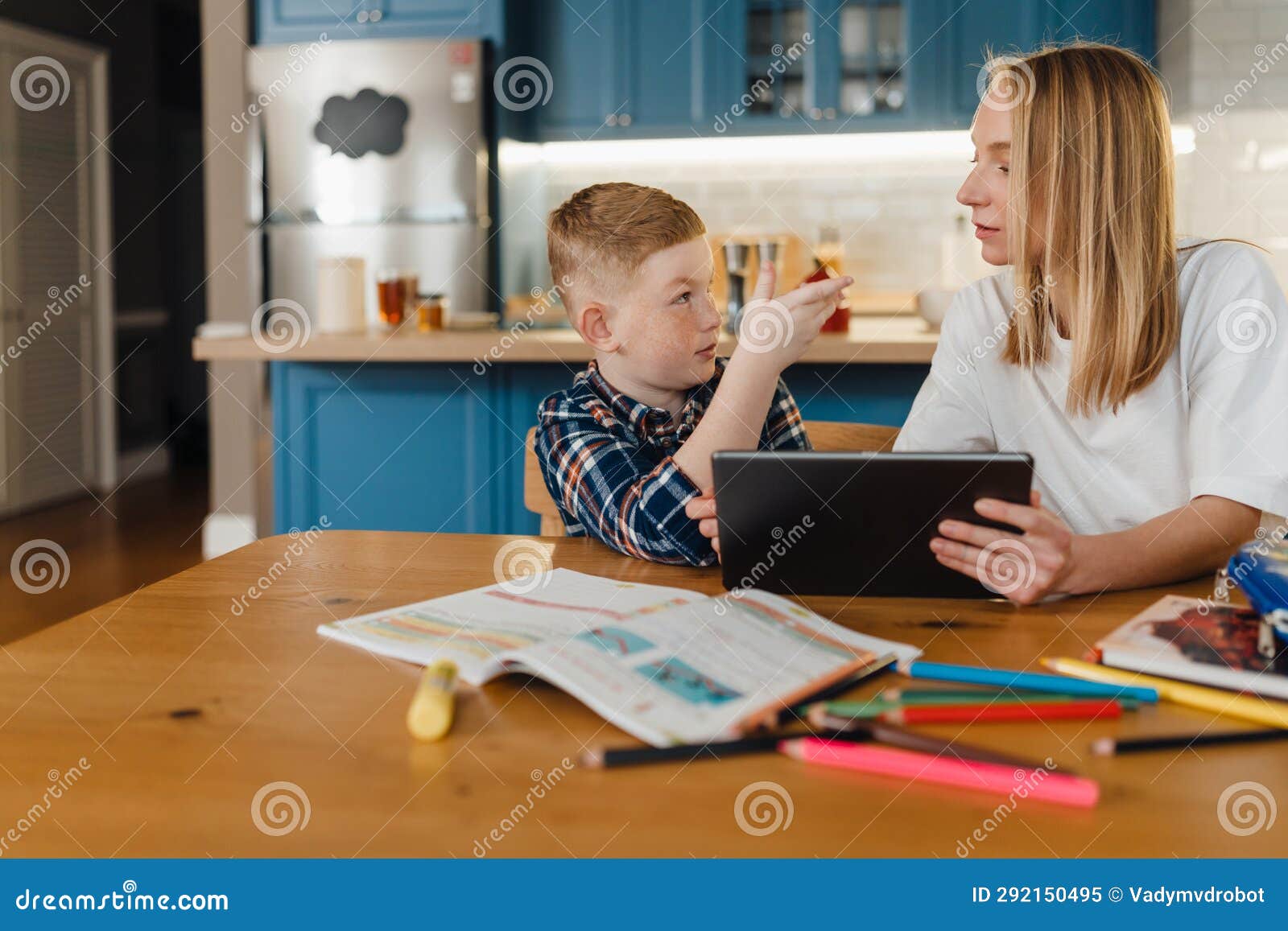 Young Mom with Her Son Using Tablet Computer while Sitting in Kitchen ...