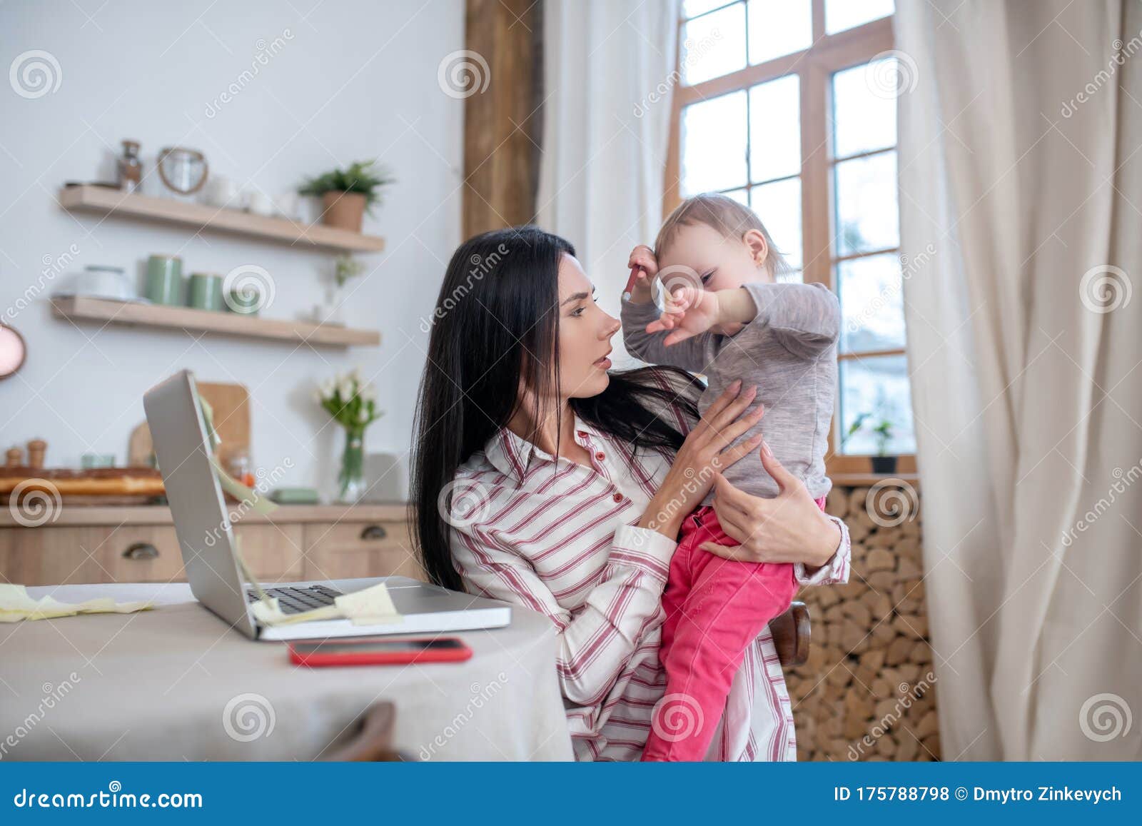 Young Mom Holding Baby, Distracted from Work Stock Photo - Image of ...