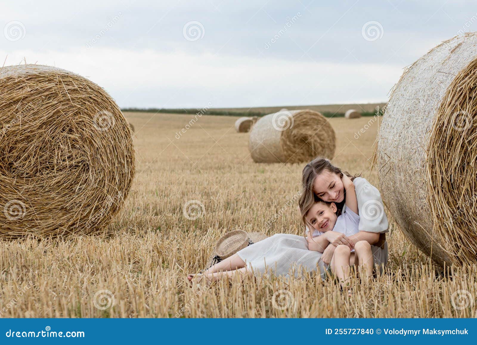Young Mother and Her Son are Hugging Near Straw Bales in a Field. a ... Young Mother and Her Son are Hugging Near Straw Bales in a Field. a ...