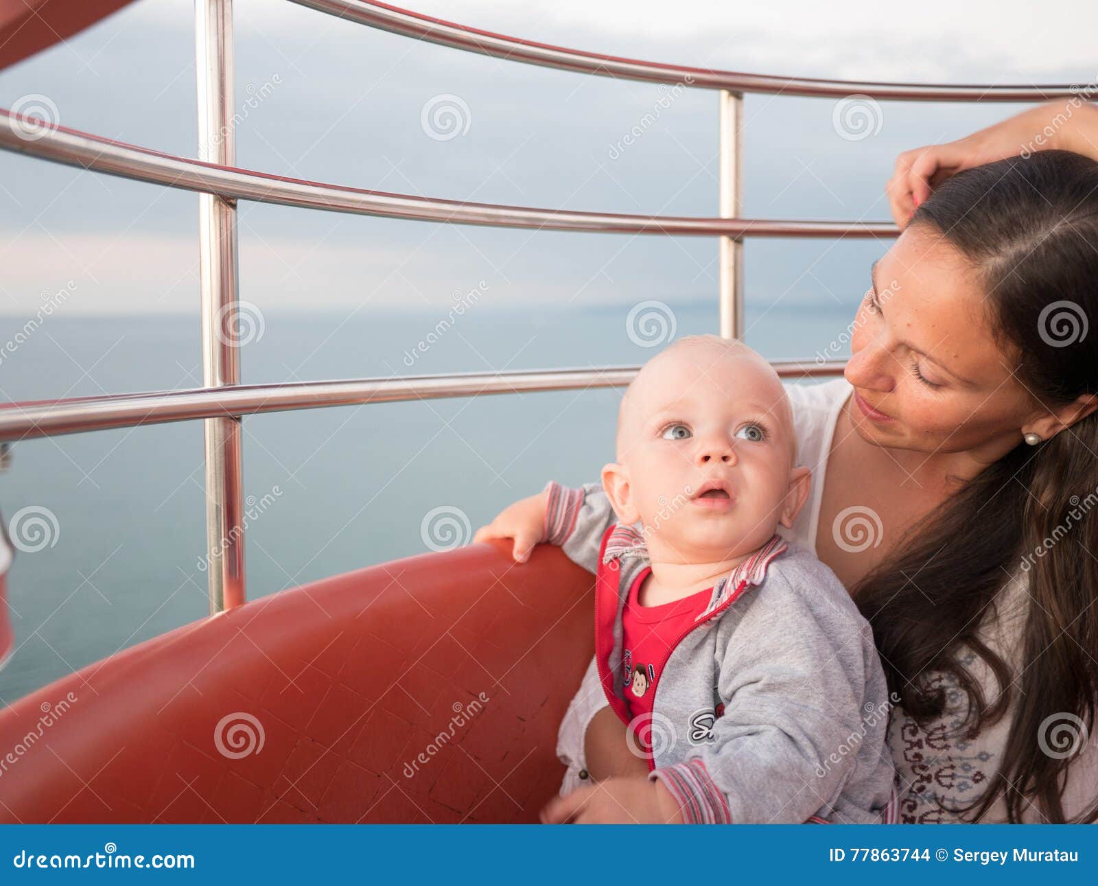 Young Mother with Her Toddler Son Playing Outdoors on Ferris Wheel ... Young Mother with Her Toddler Son Playing Outdoors on Ferris Wheel ...