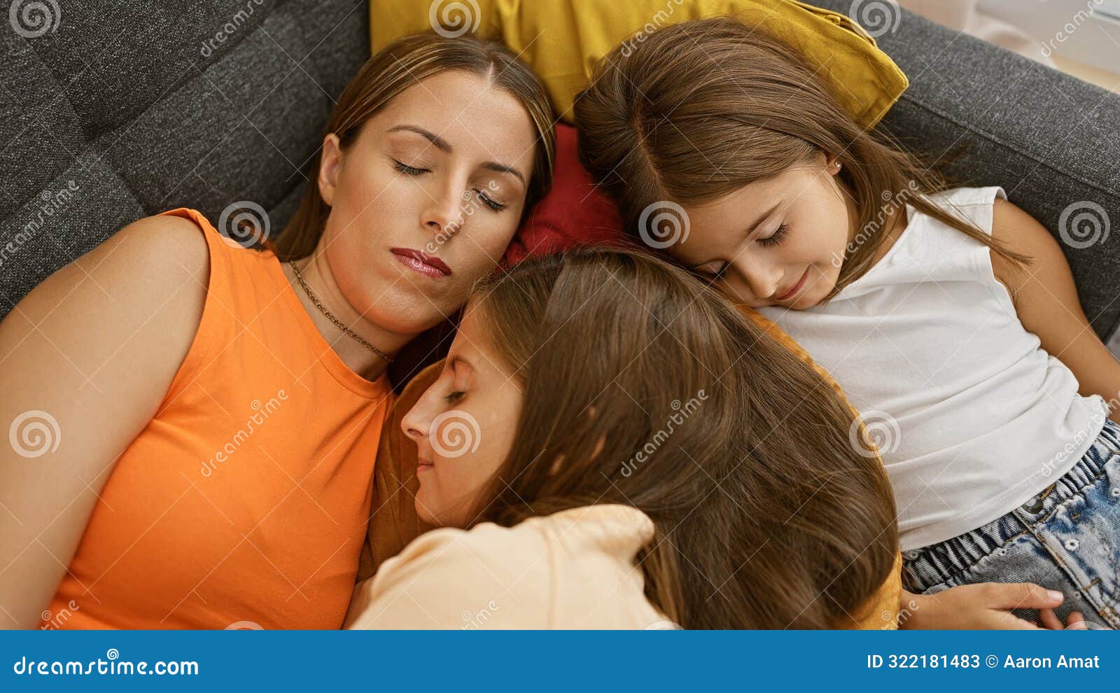 A Young Mother And Her Two Daughters Sleeping Together On A Sofa In A