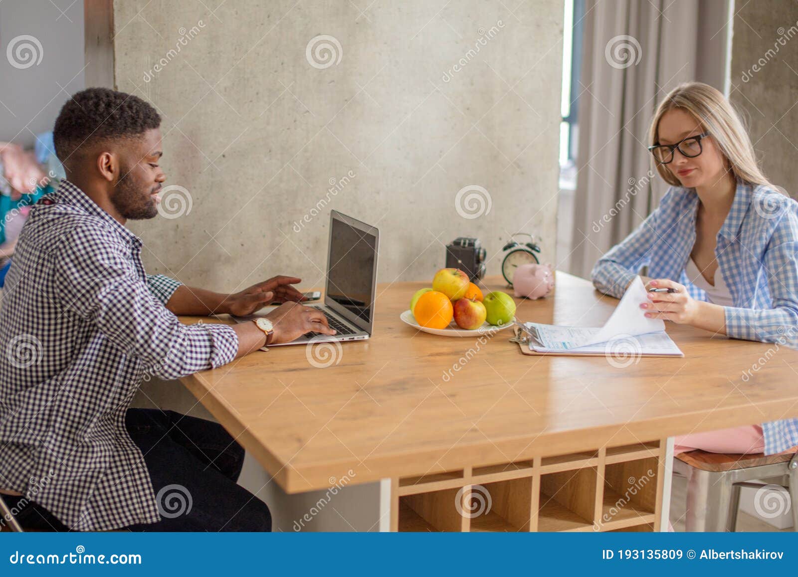 Young Couple Sitting at the Table and Working with a Laptop and ...