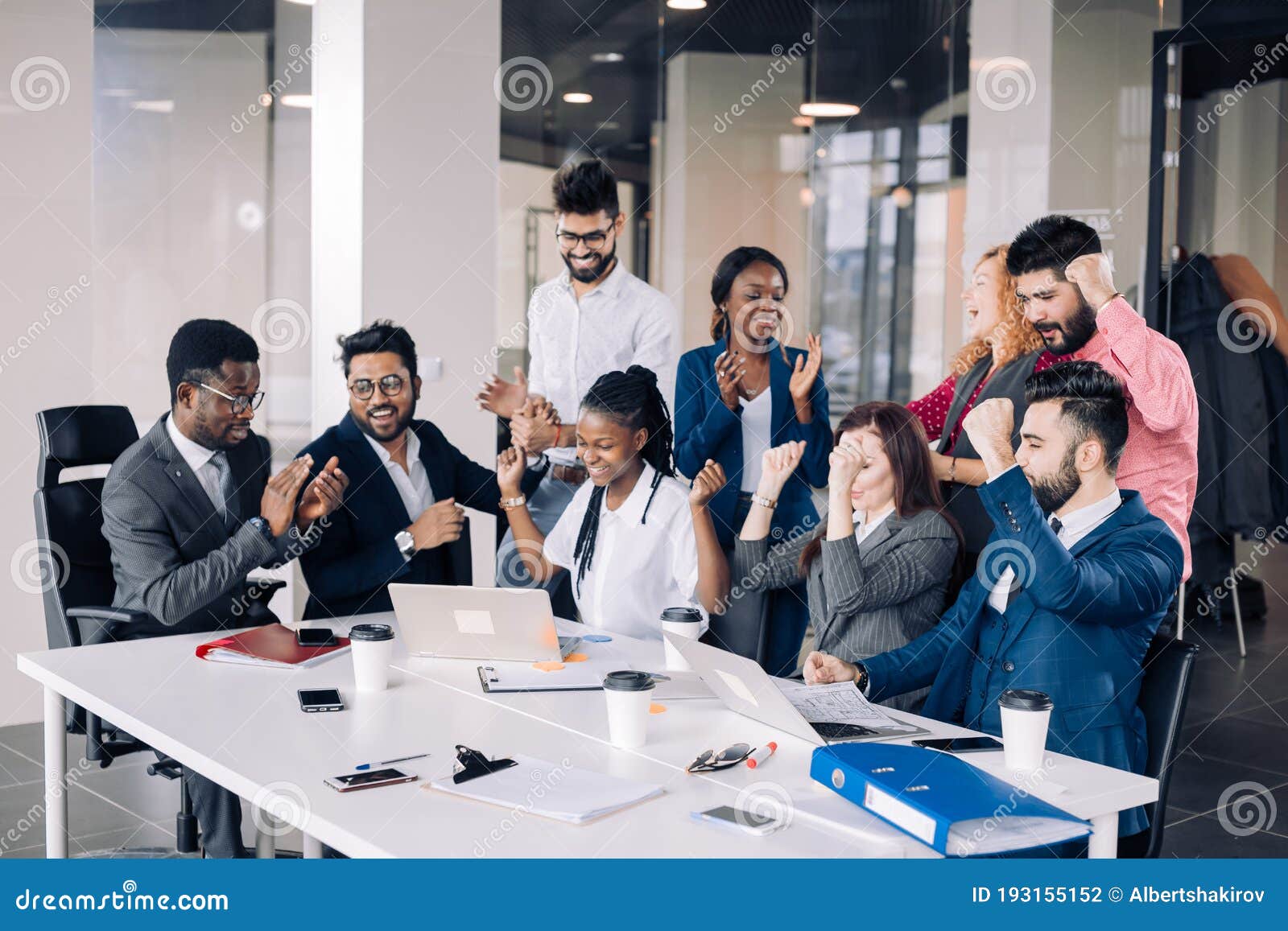 Young Multi-ethnic Work Team Exchanges Ideas Gathering Around Laptop ...
