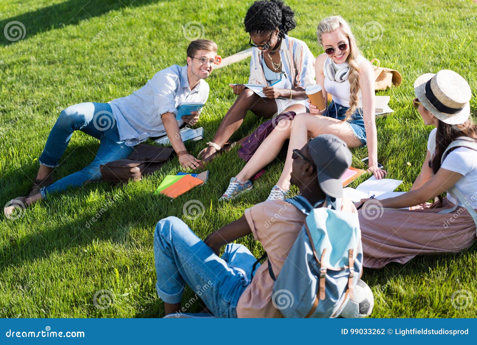 Young Multiethnic Students Talking and Reading Books while Resting on ...