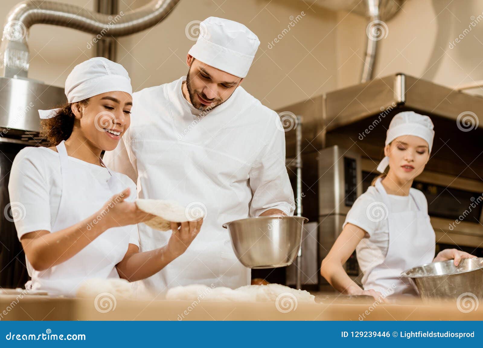 Young Multiethnic Team of Bakers Working Together Stock Photo - Image ...