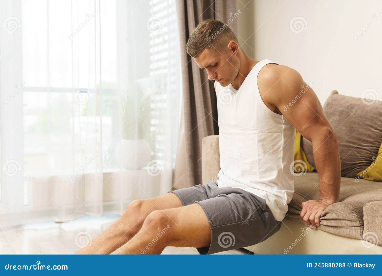 Man Doing Triceps Dips on Edge of Sofa during Home Workout Stock Photo ...