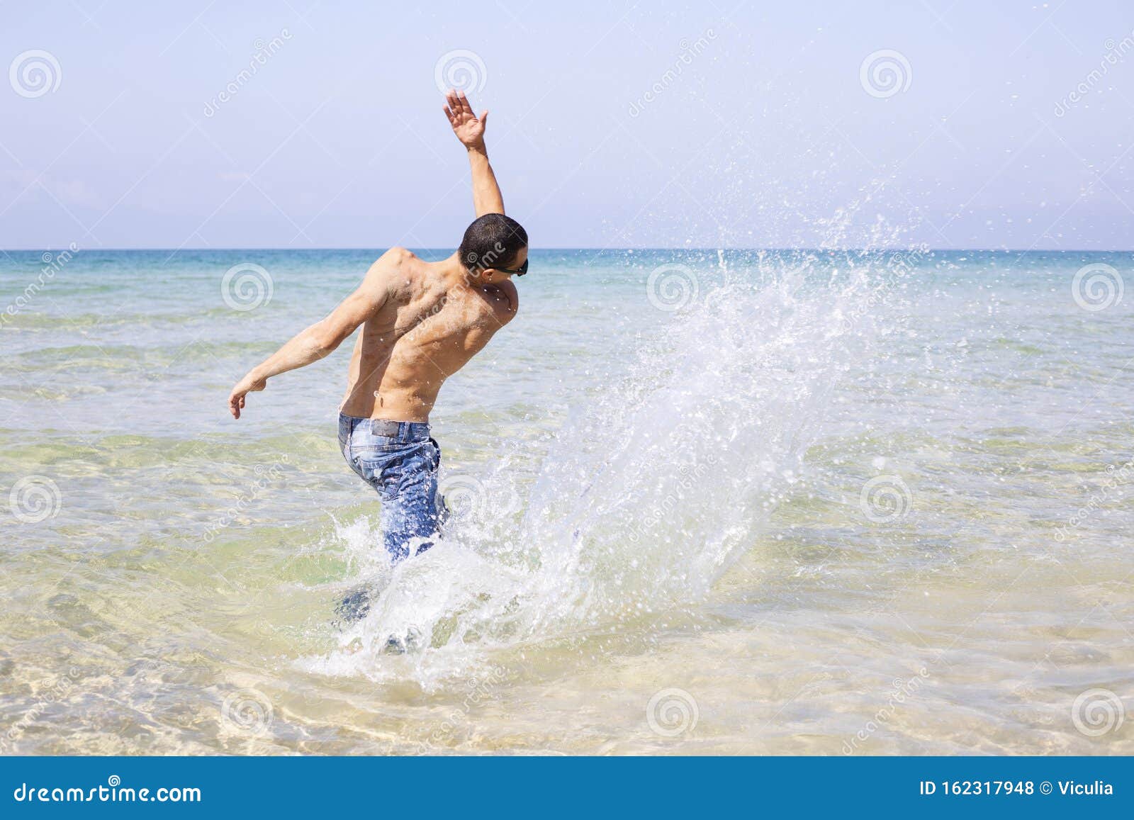 Young Muscular Man Posing and Splashing Around in the Sea Stock Photo ...