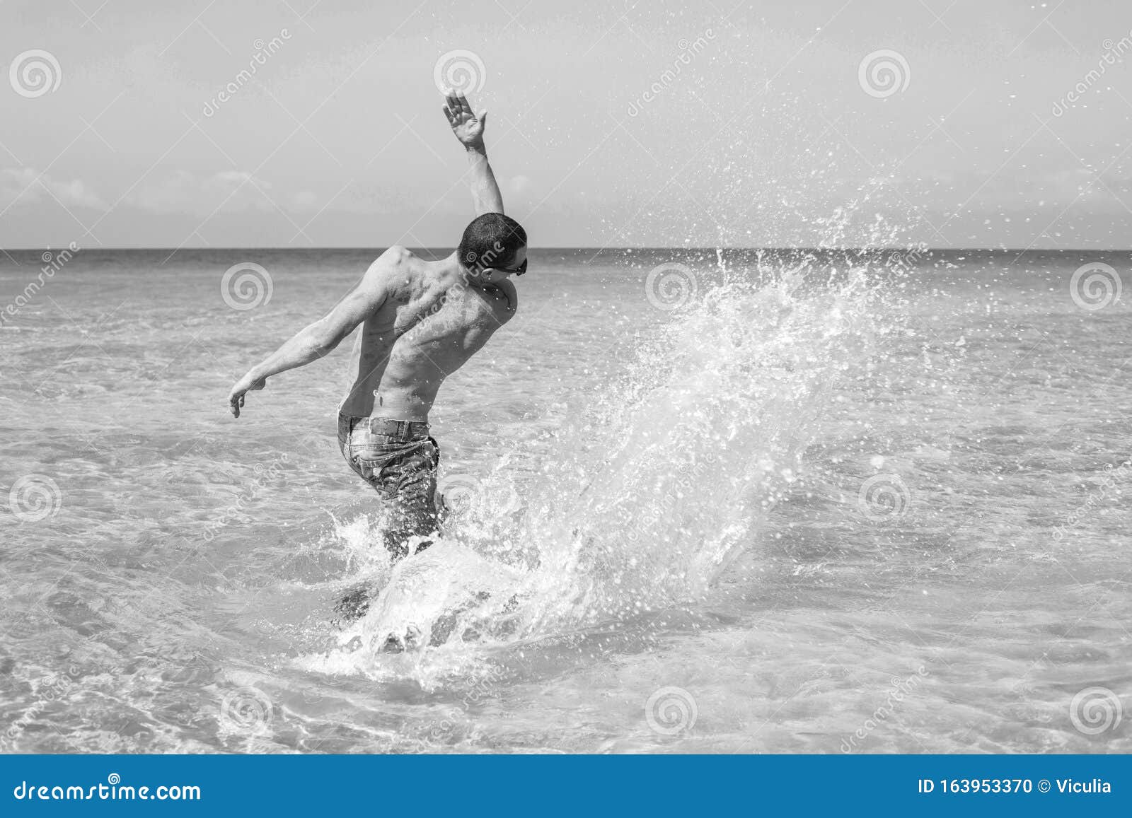 Young Muscular Man Posing and Splashing Around in the Sea Stock Photo ...