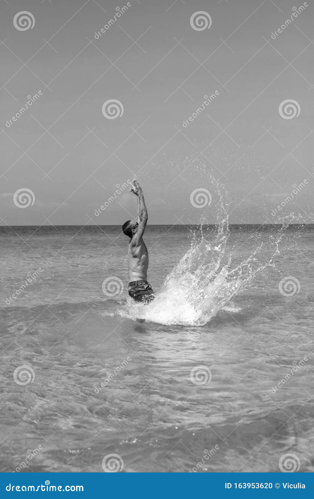 Young Muscular Man Posing and Splashing Around in the Sea Stock Photo ...