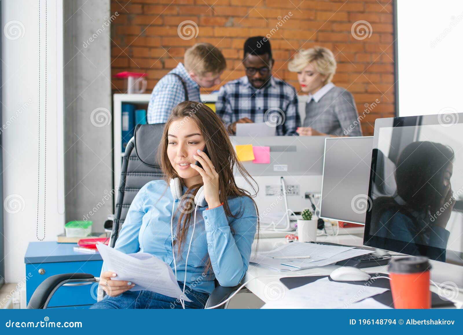 Young Nice Administrative Assistant in Headphones Using the Smart Phone ...