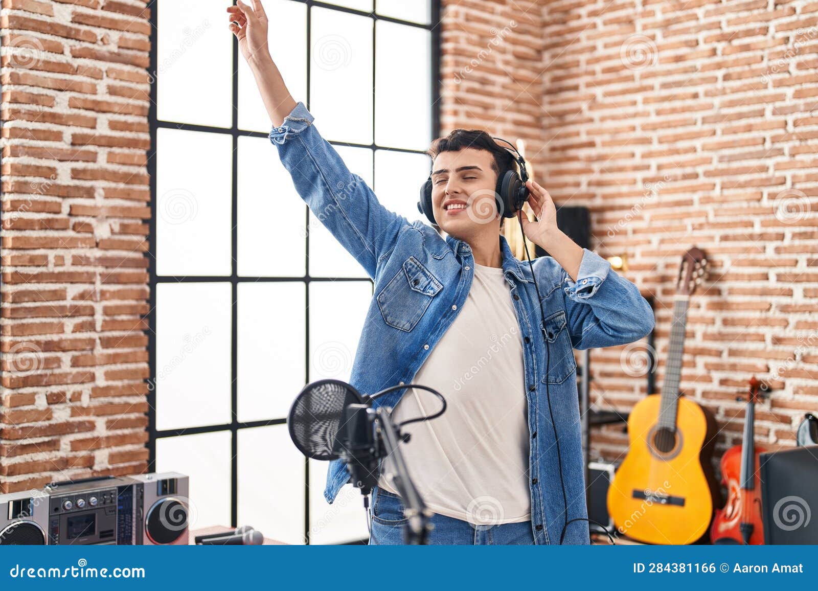 Young Non Binary Man Artist Listening To Music Dancing at Music Studio ...