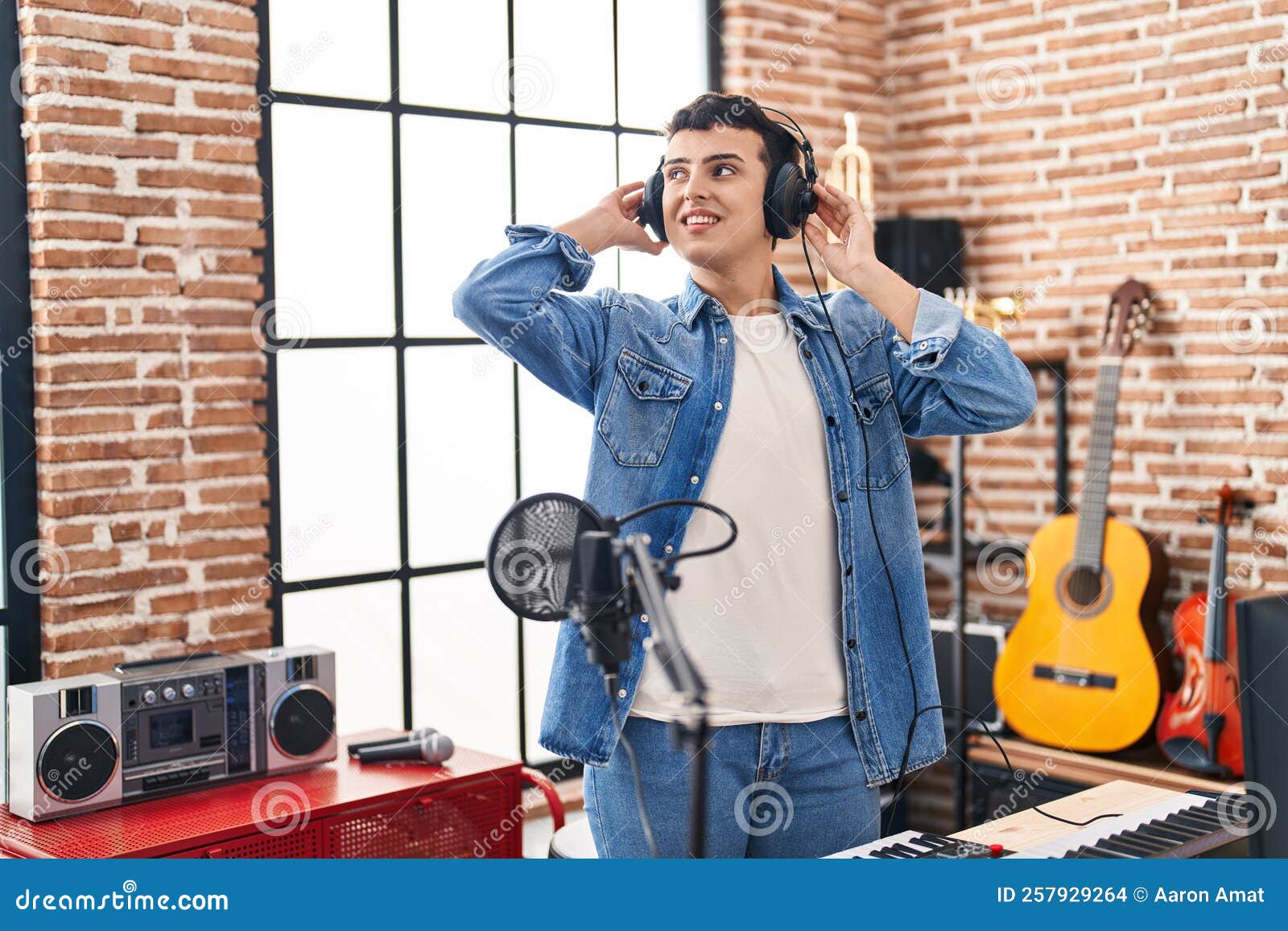 Young Non Binary Man Artist Listening To Music at Music Studio Stock ...